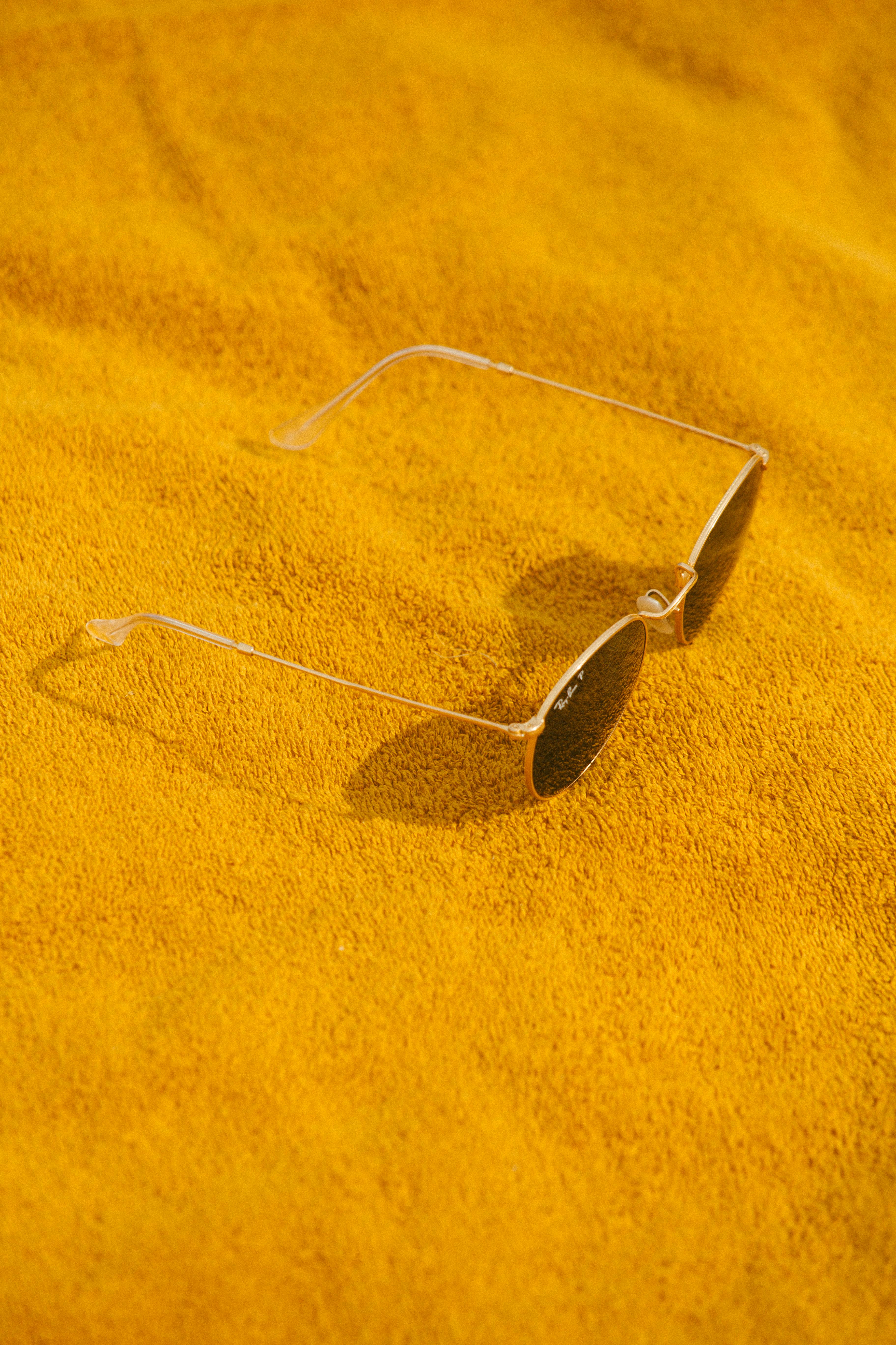 Kacamata Hitam Di Handuk Kuning Cerah Di Luar Ruangan · Foto Stok Gratis