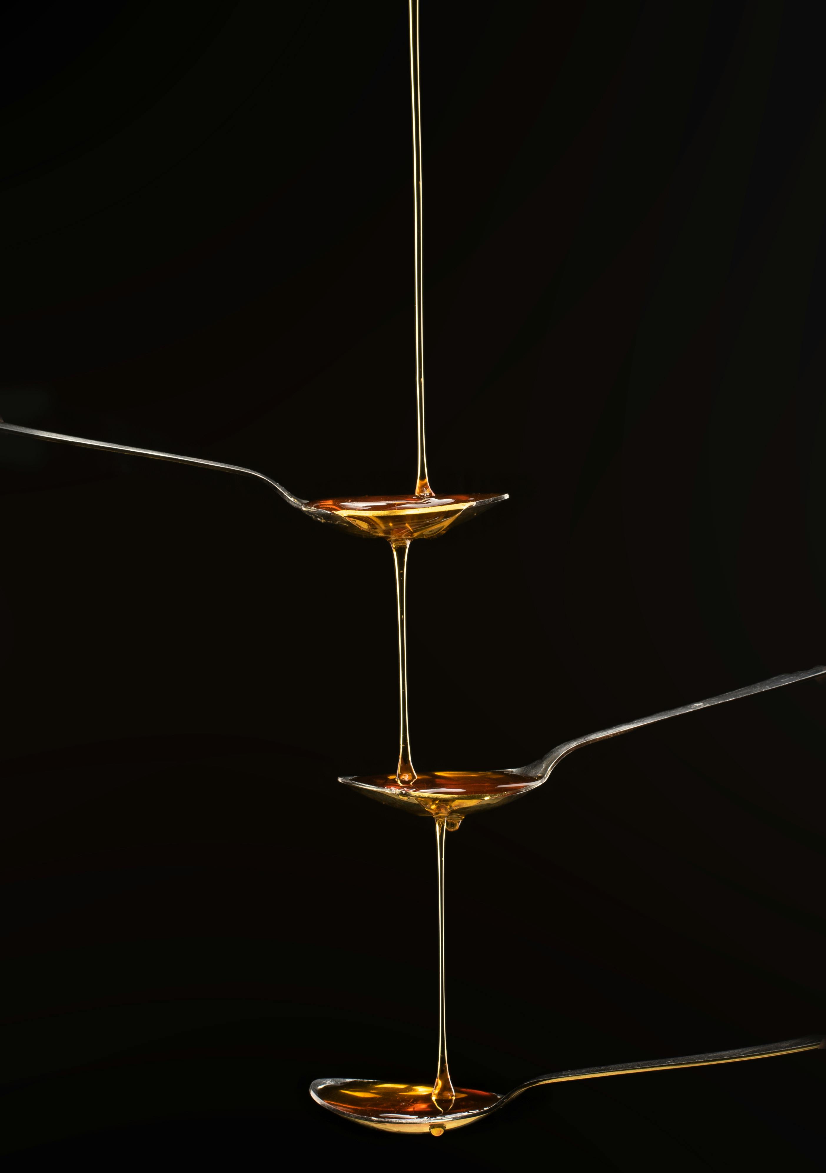 Close-up of Honey Dripping from Spoons · Free Stock Photo