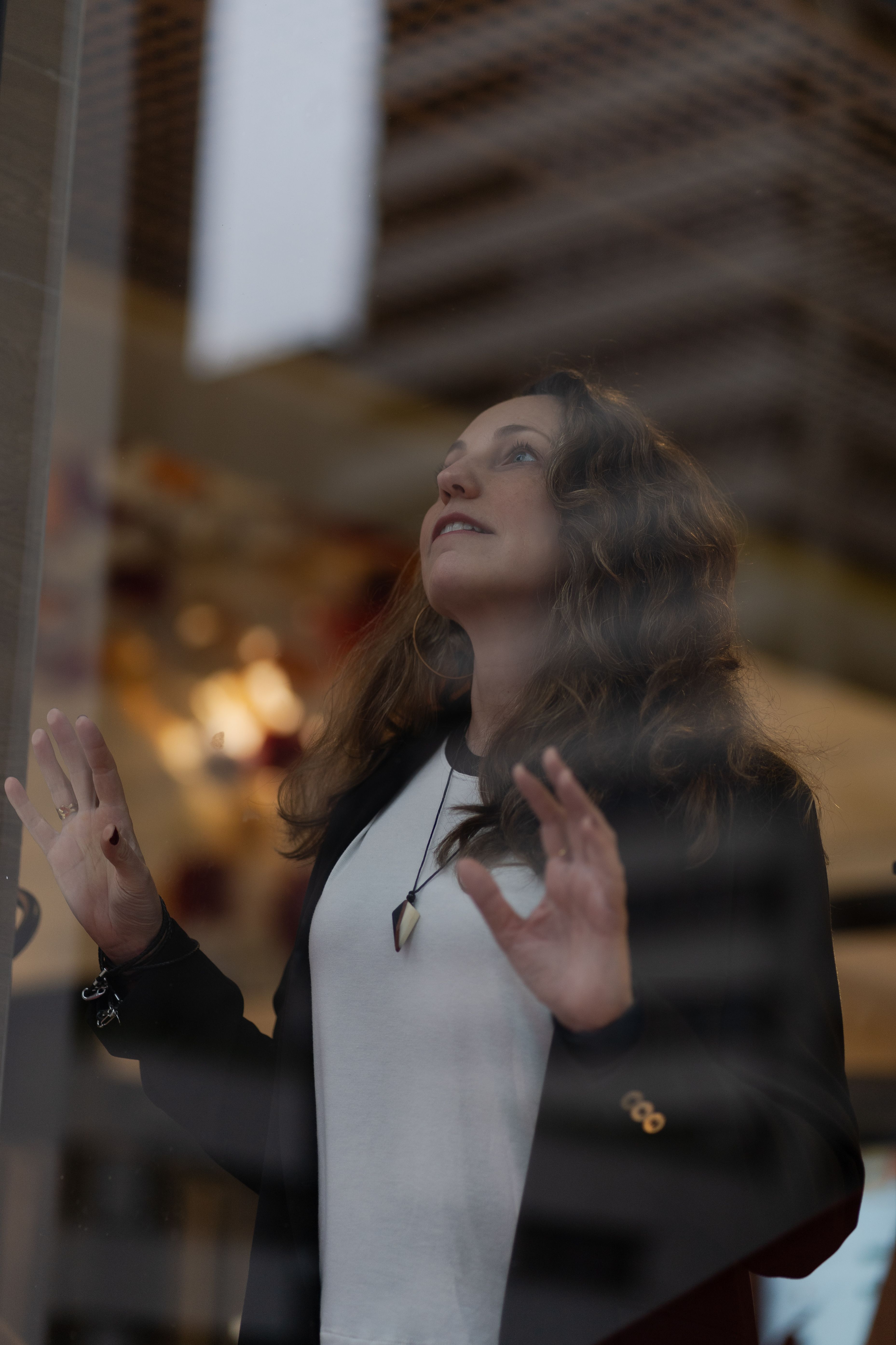 Woman Looking Through Glass in Modern Interior · Free Stock Photo