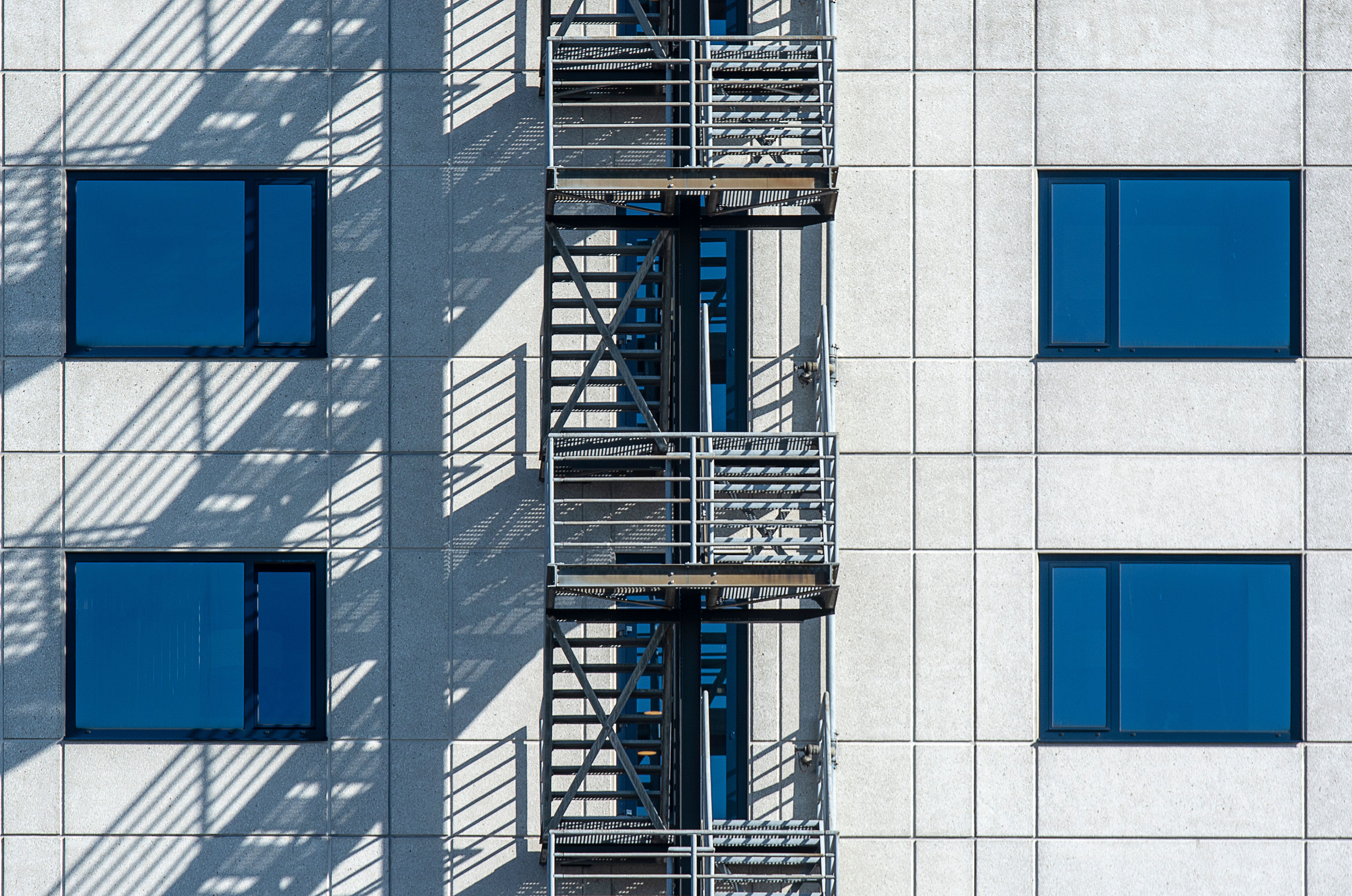 Modern Building Facade with Fire Escape and Shadows · Free Stock Photo