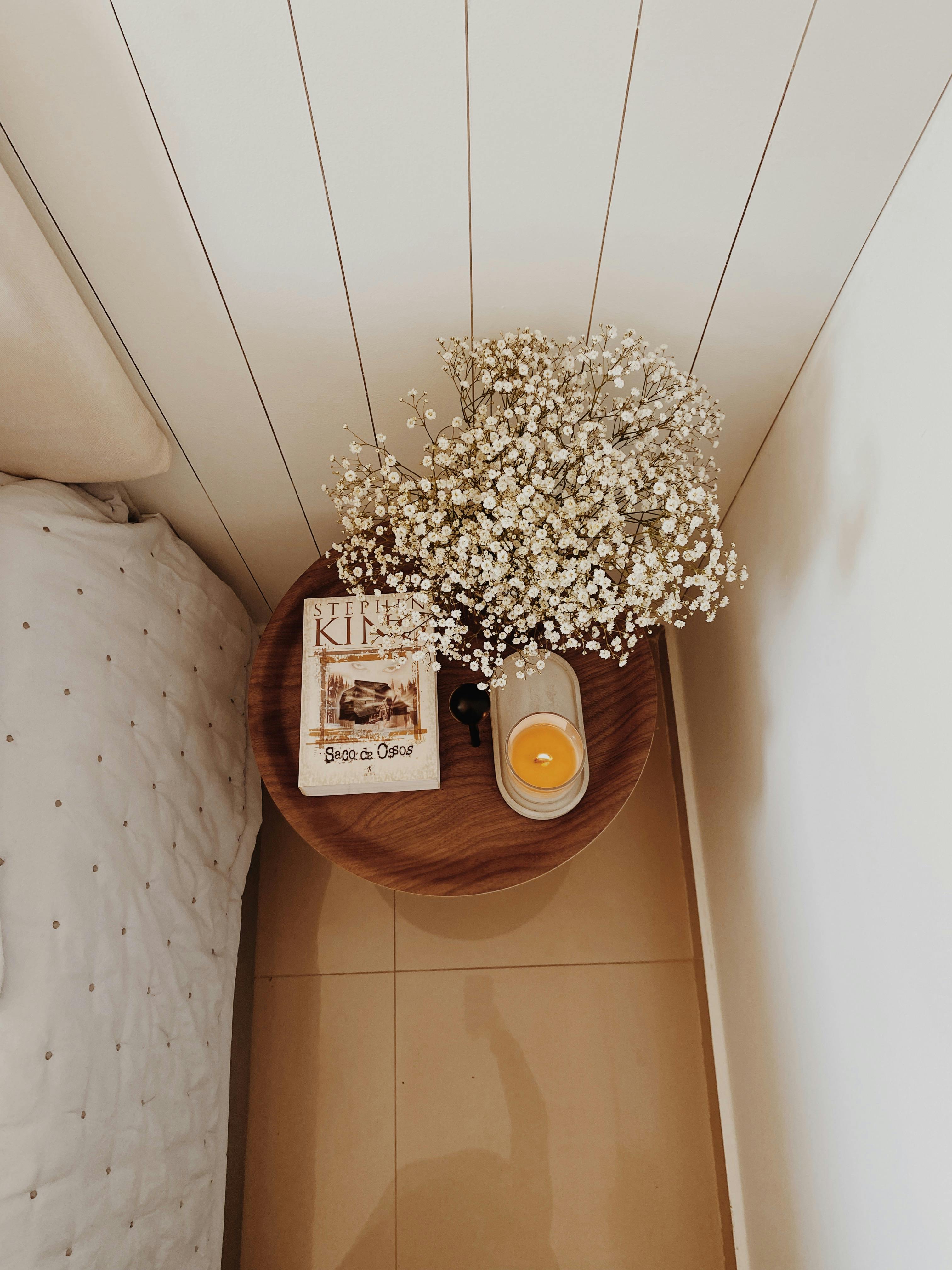 Cozy Bedside Table with Baby's Breath and Candle · Free Stock Photo