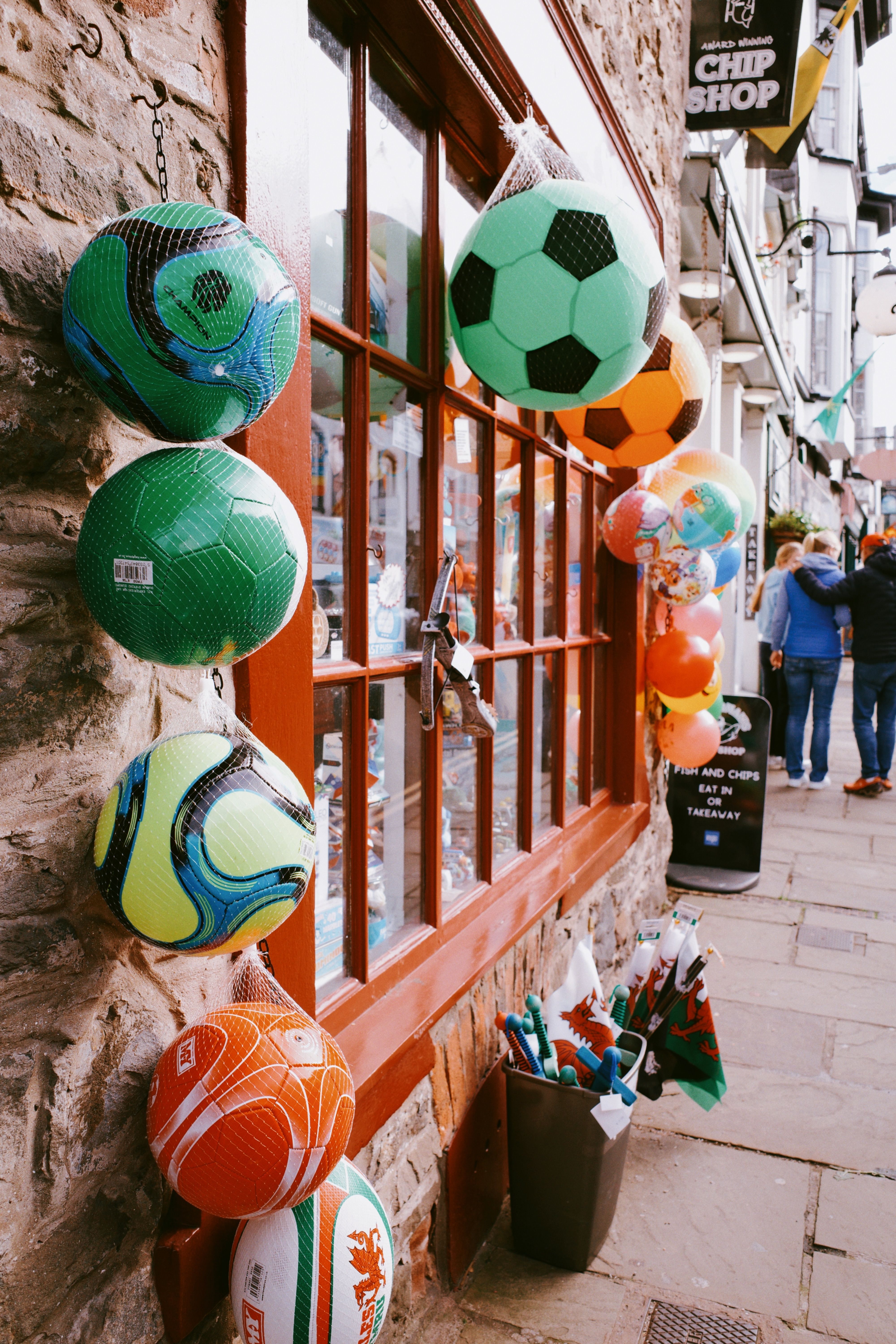 Colorful Sports Balls Hanging Outside a Shop · Free Stock Photo