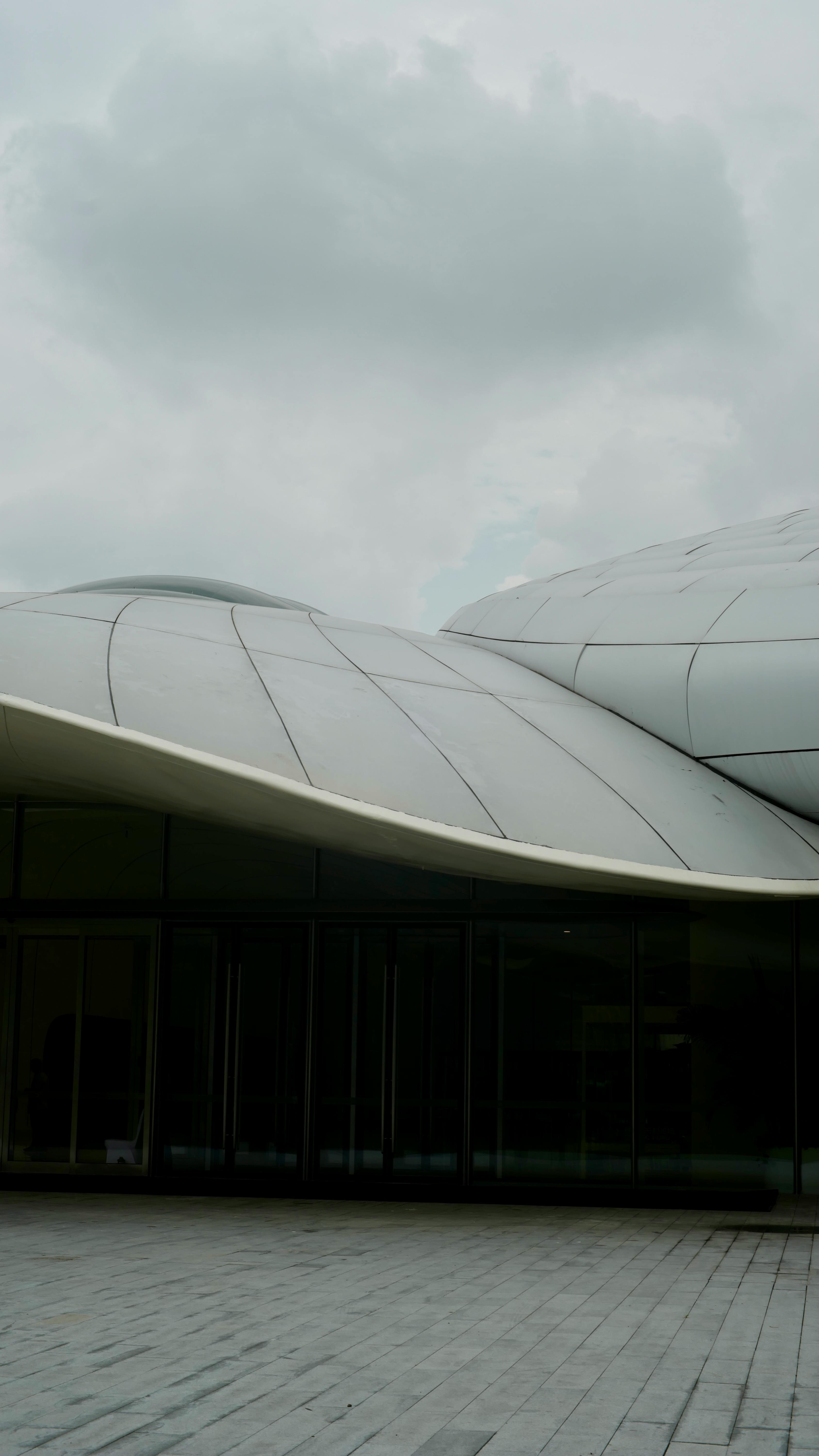 Futuristic Building with Curved Metallic Roof · Free Stock Photo