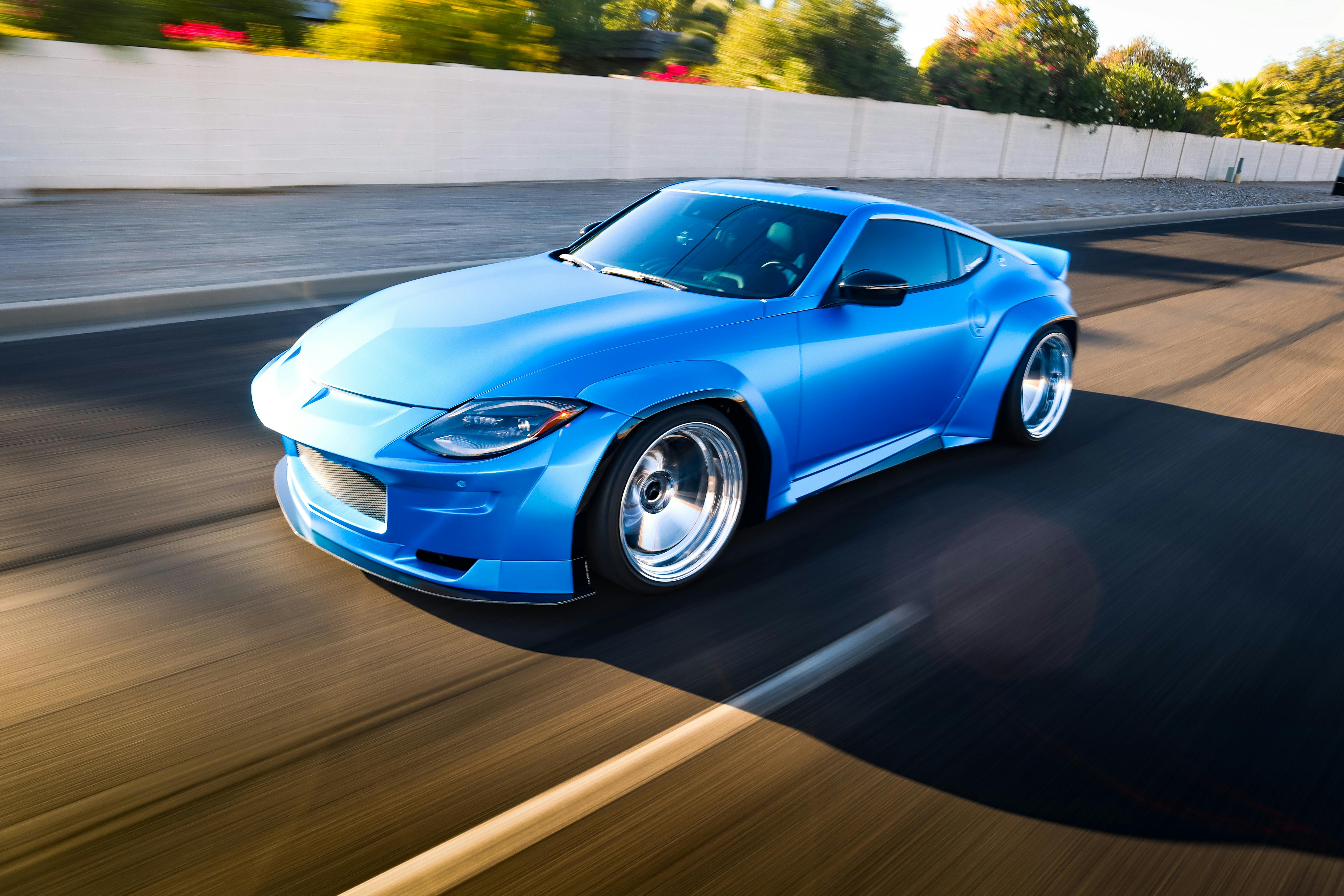 Blue Modified Car in Motion on Highway · Free Stock Photo