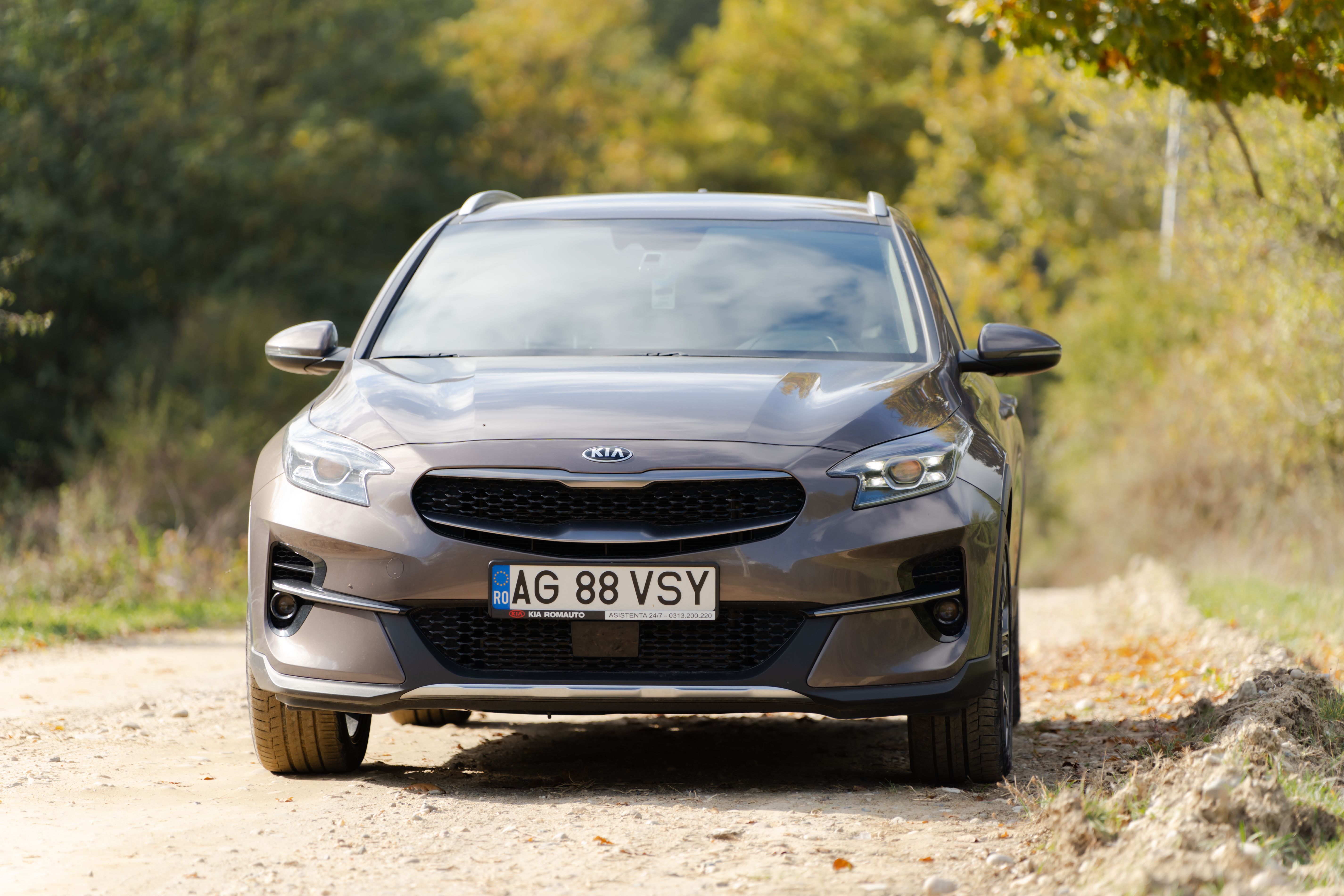 Kia car on a country road in fall season · Free Stock Photo