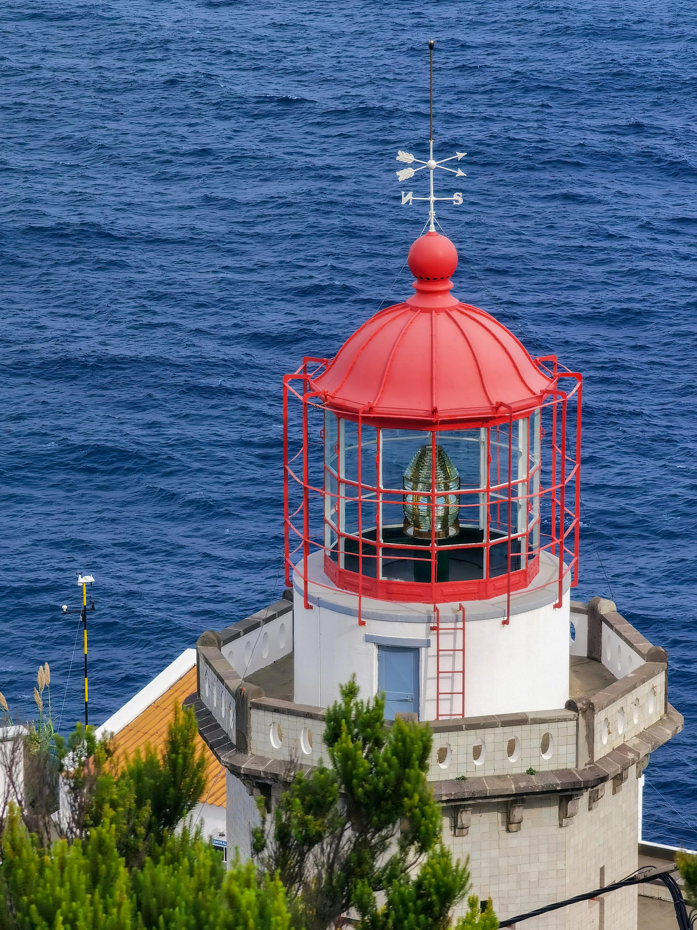 Stunning Red-Topped Lighthouse Overlooking the Ocean · Free Stock Photo
