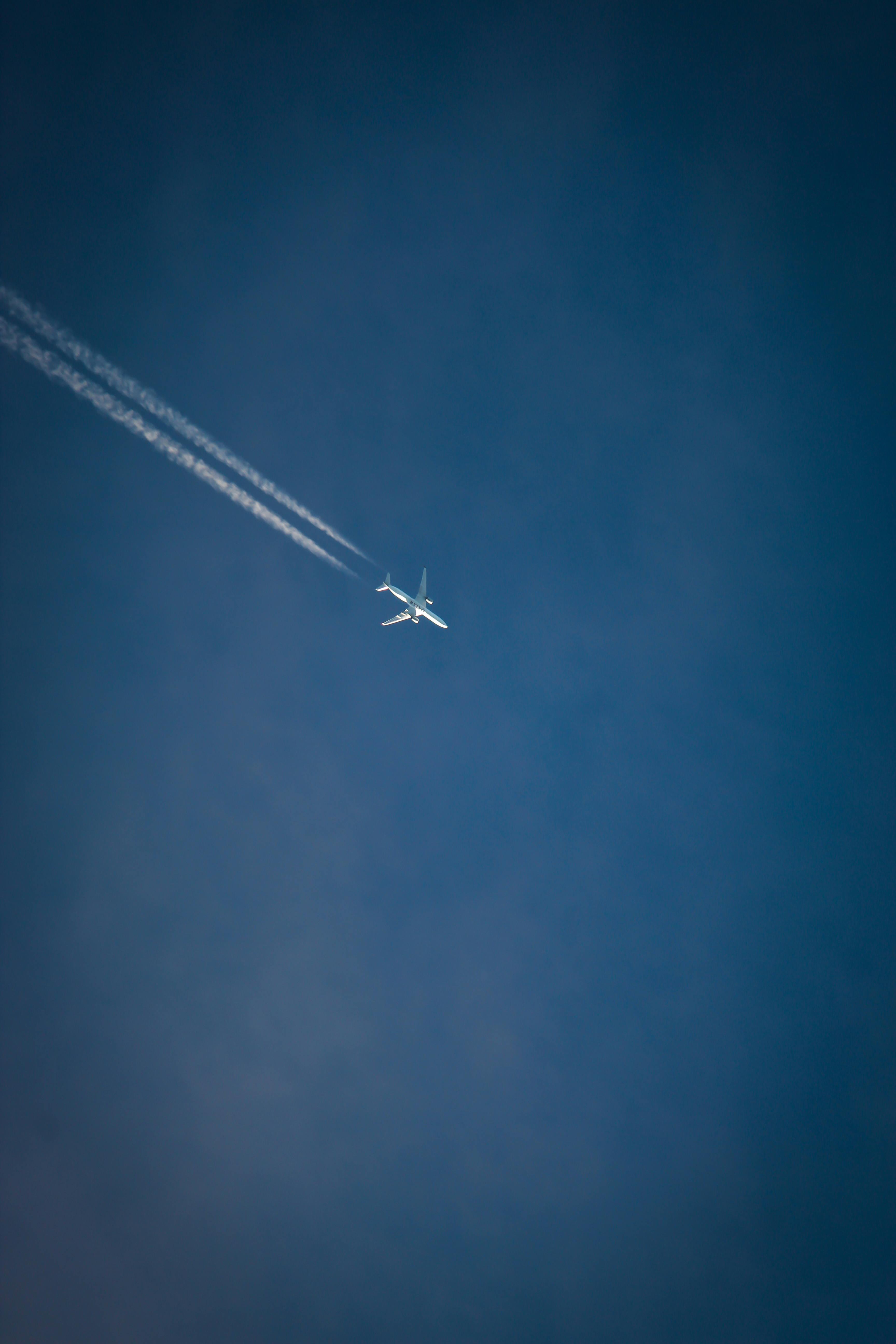 Airplane Flying High Above Clouds in Blue Sky · Free Stock Photo
