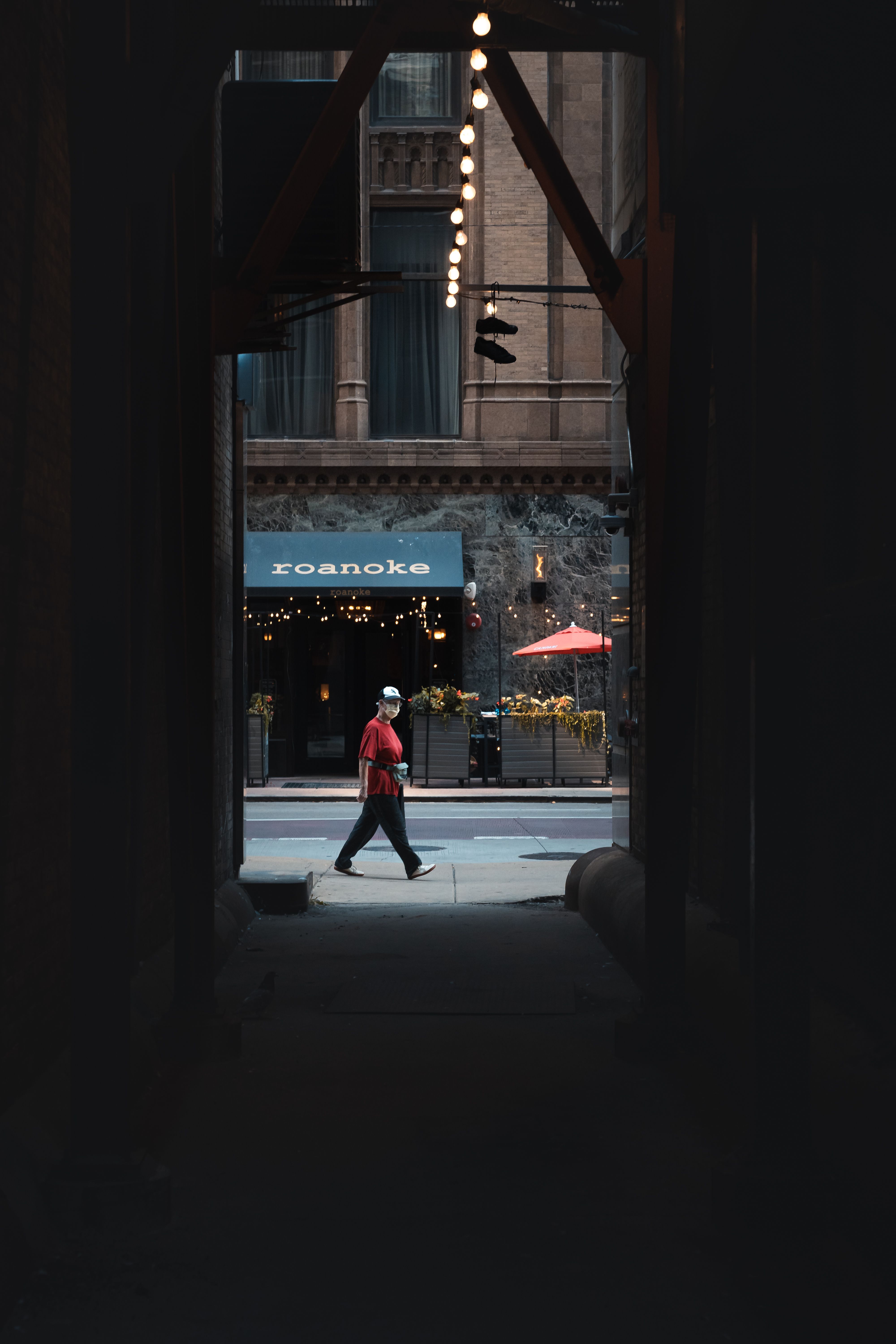 Urban Alley View with Street Cafe and Pedestrian · Free Stock Photo