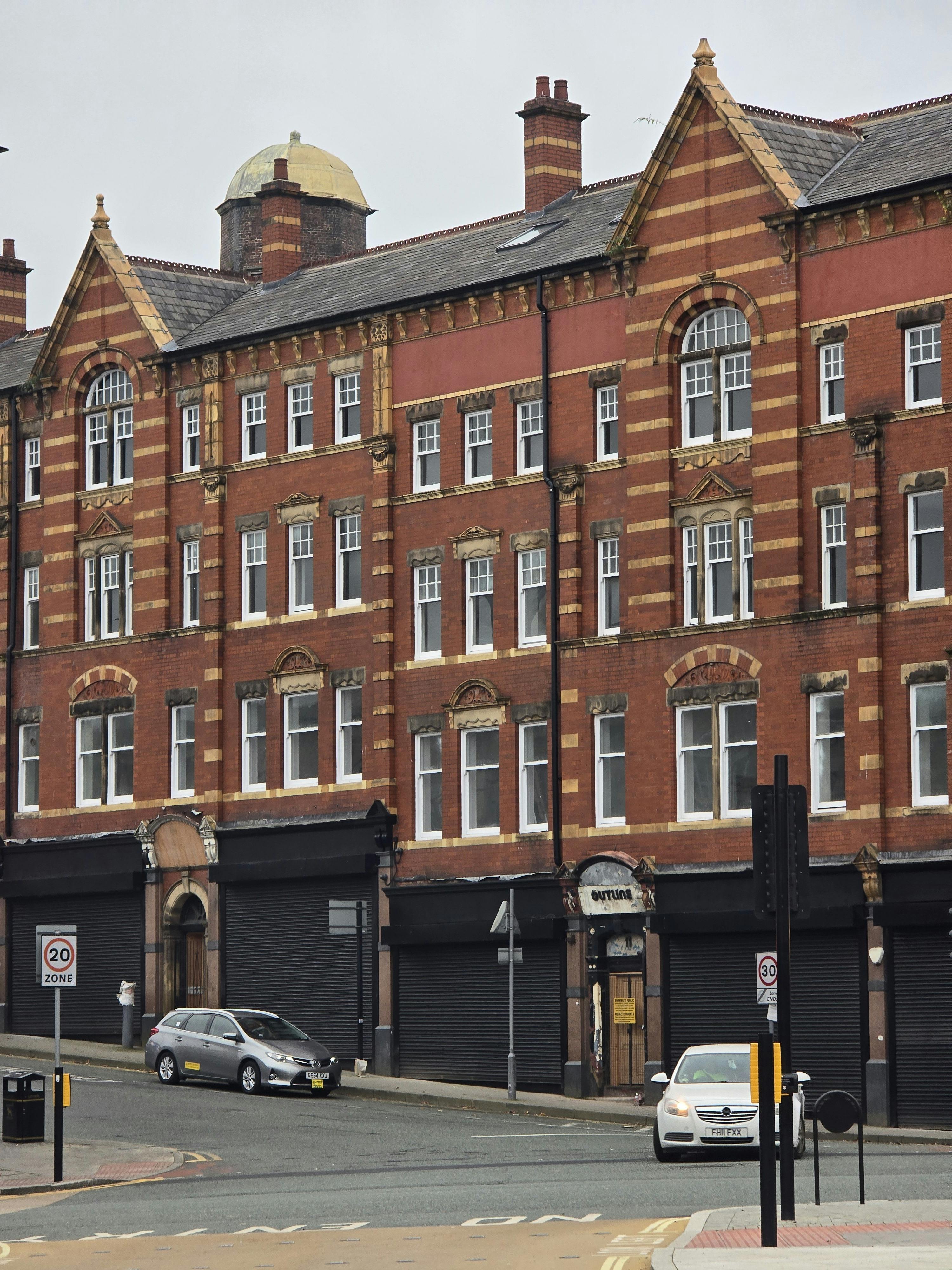 Historic Red Brick Building on Urban Street · Free Stock Photo