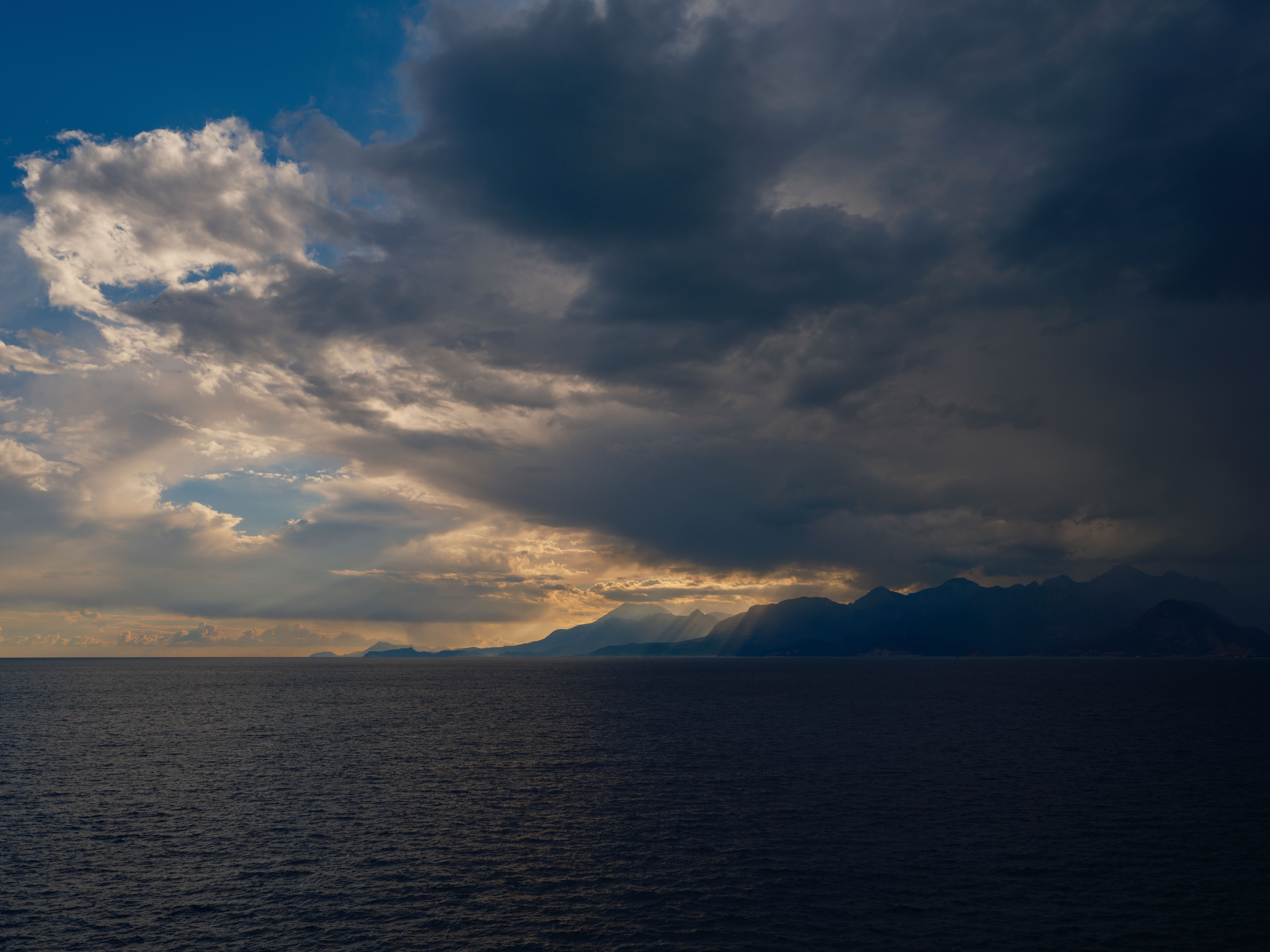 Dramatic Ocean View with Moody Clouds at Sunset · Free Stock Photo