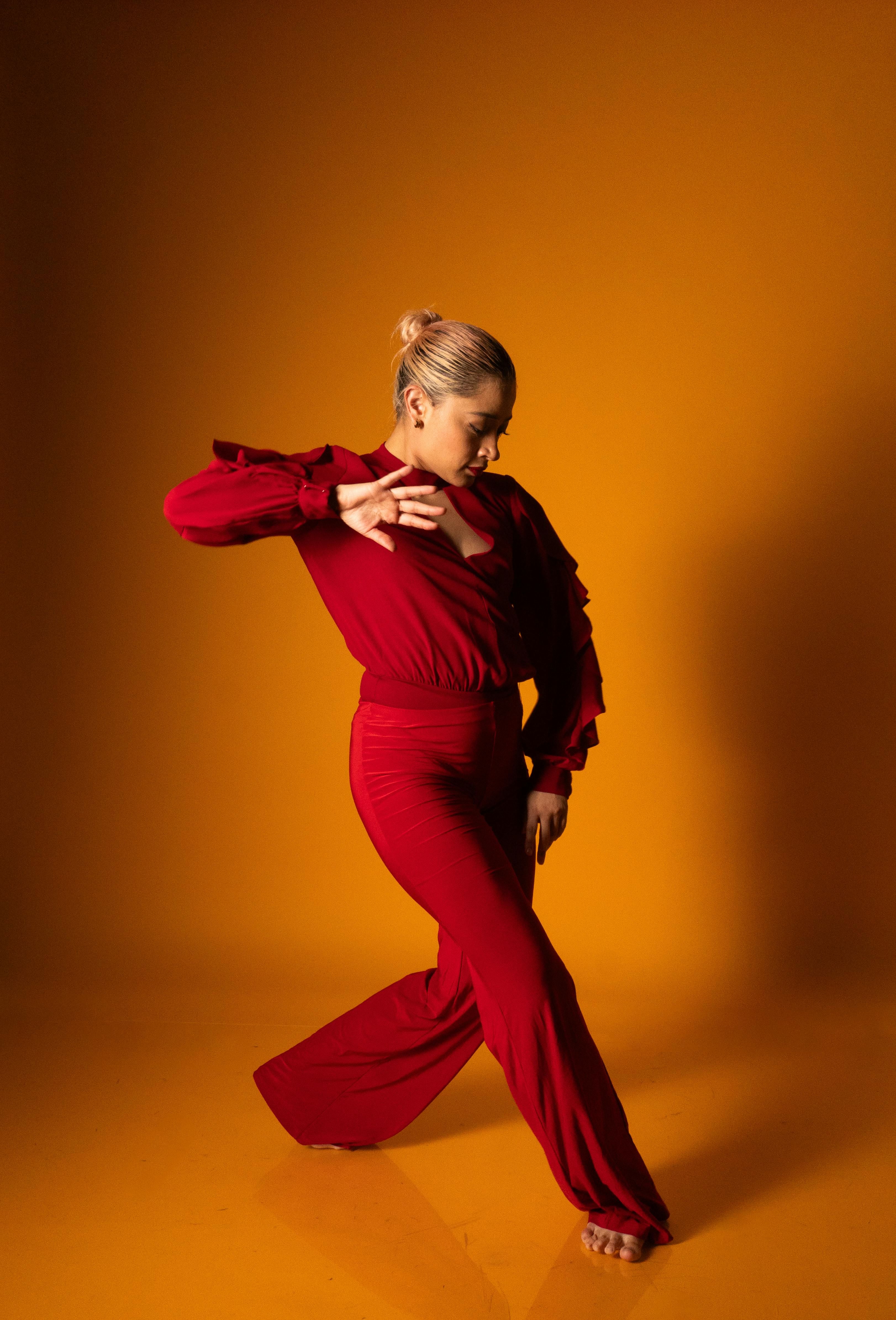 Dynamic Female Dancer in Red on Orange Background · Free Stock Photo