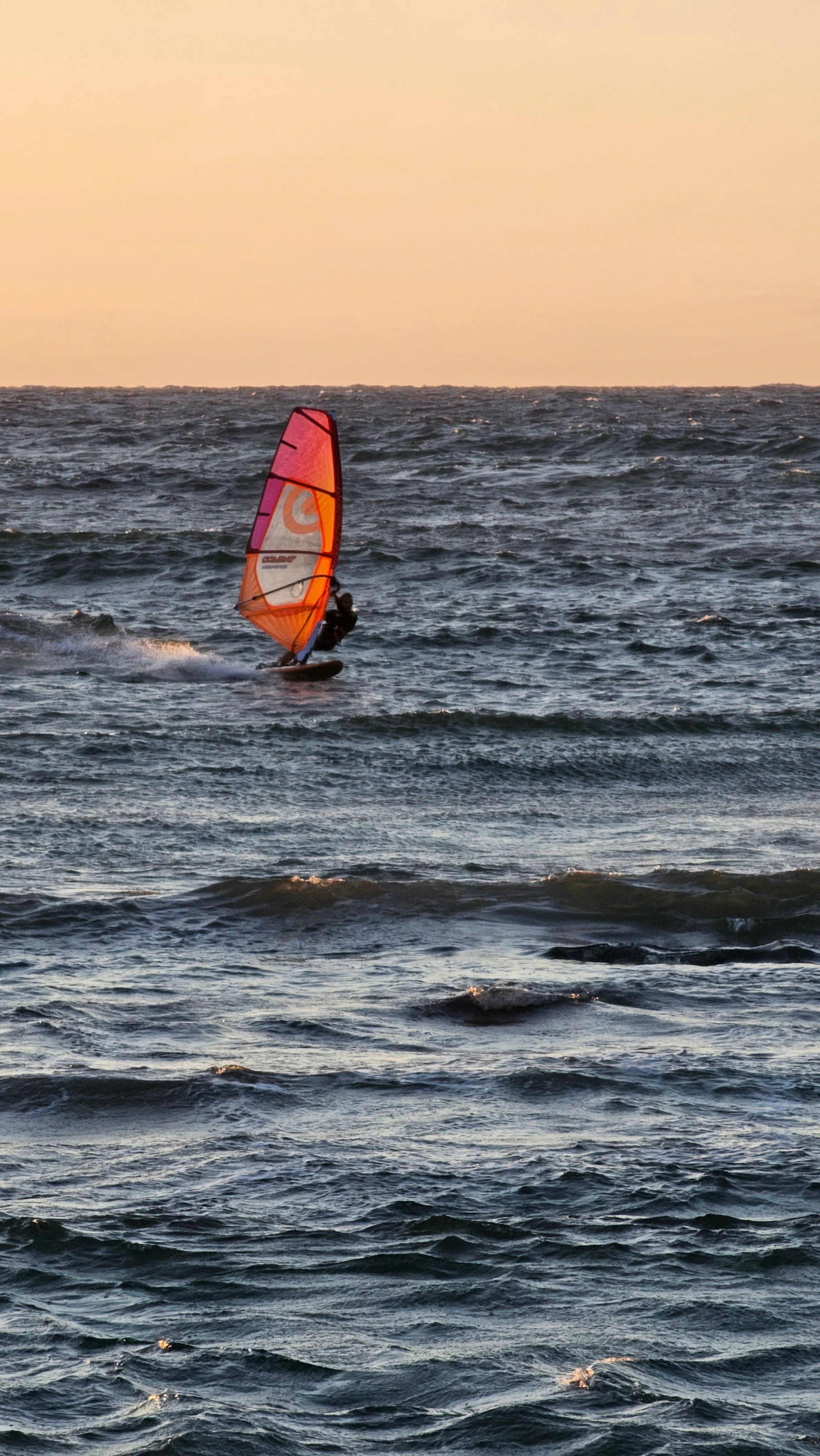 Windsurfer Enjoys Sunset Ride on Open Sea · Free Stock Photo