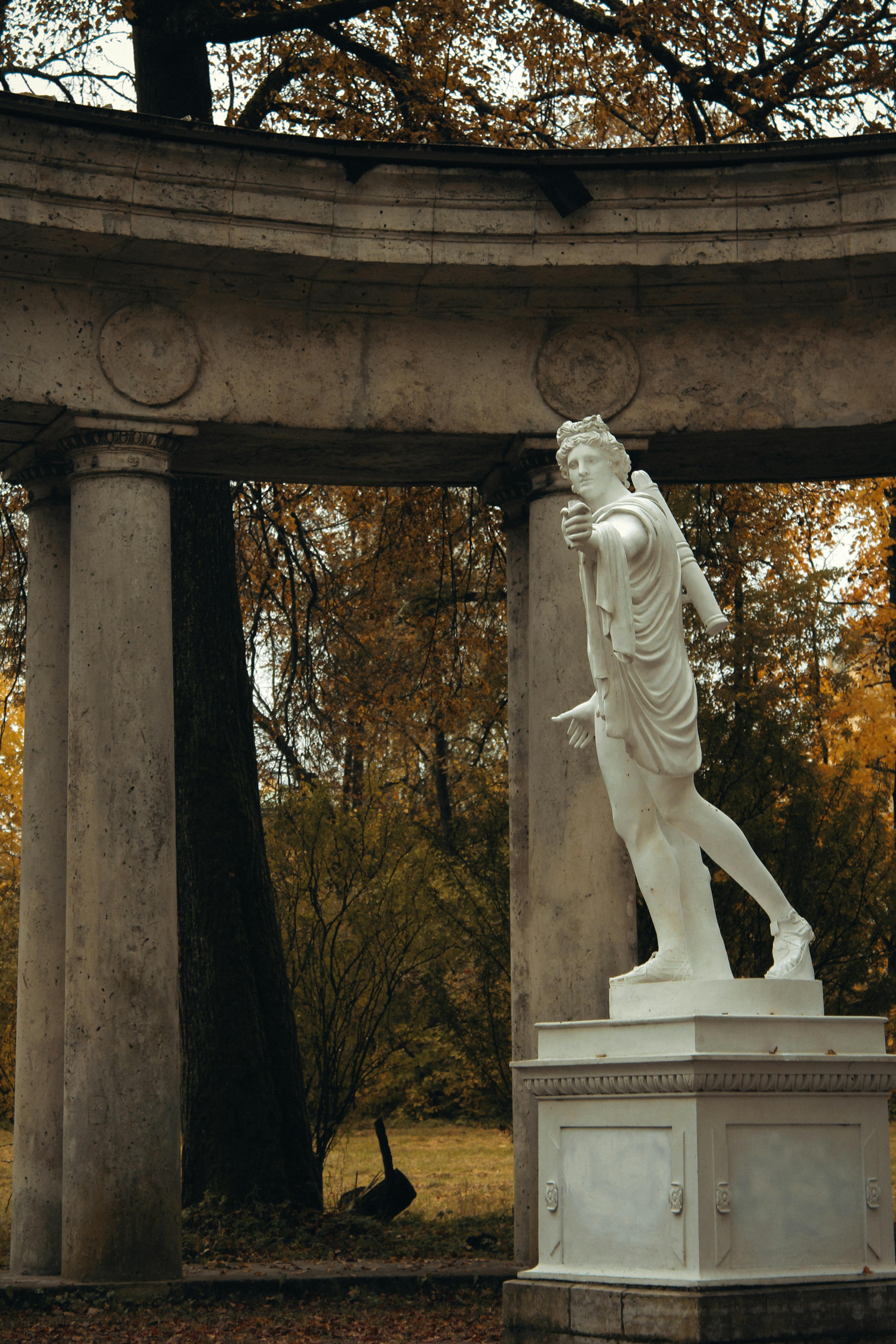 Classical Statue Amidst Ancient Columns in Autumn · Free Stock Photo