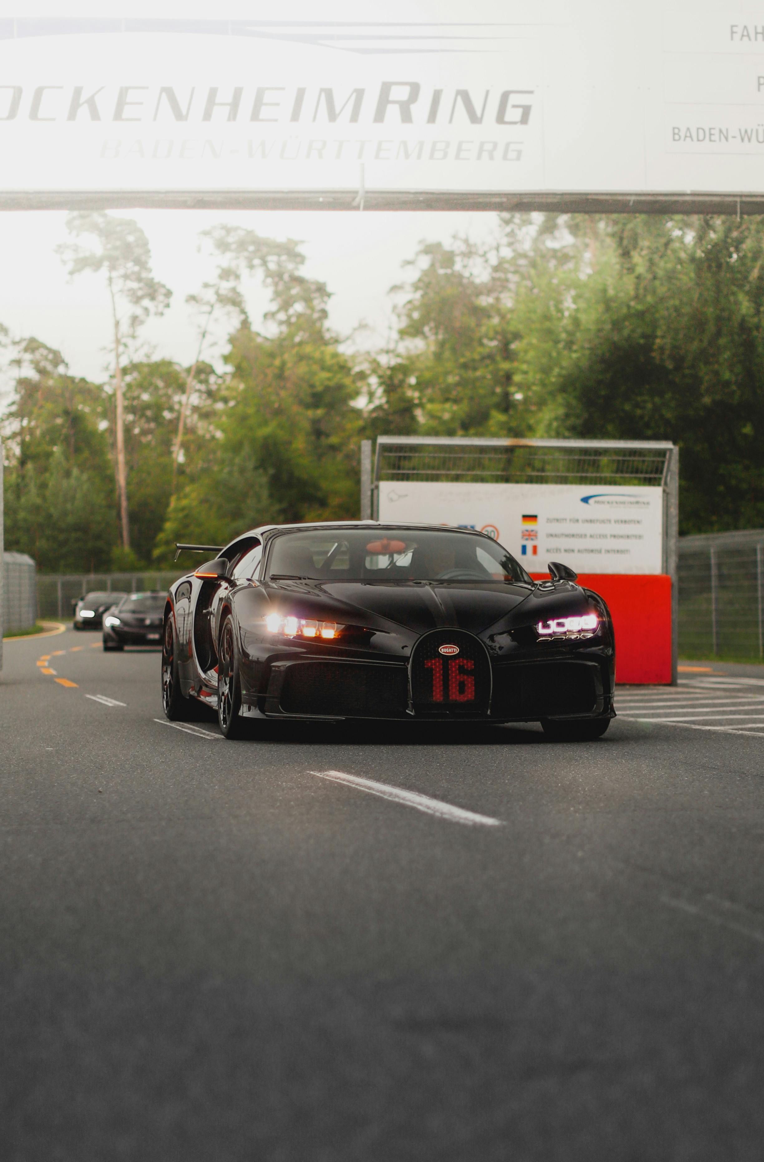 Sleek Black Sports Car on Iconic Racetrack · Free Stock Photo