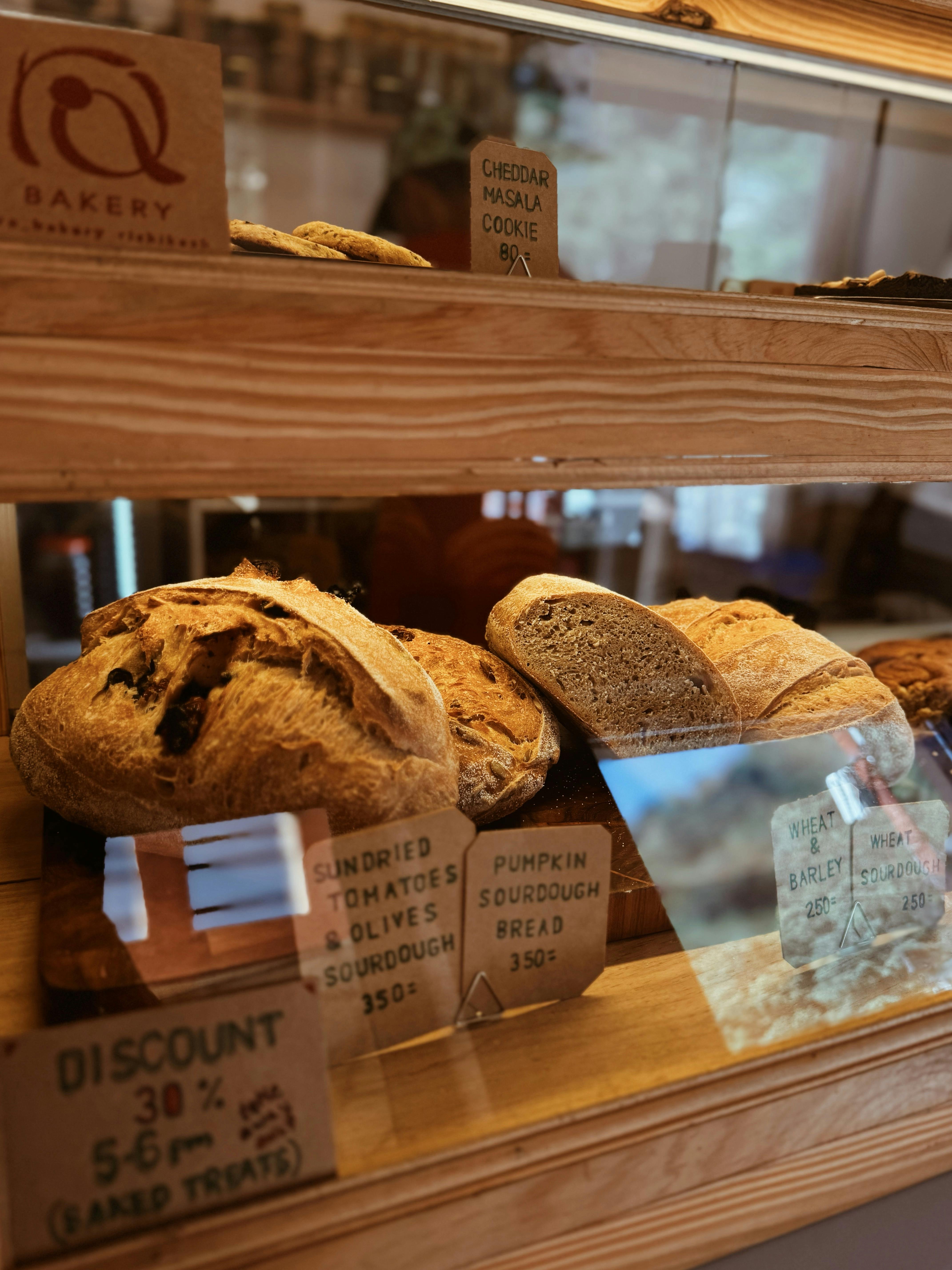 Artisanal Breads Displayed in Bakery Showcase · Free Stock Photo