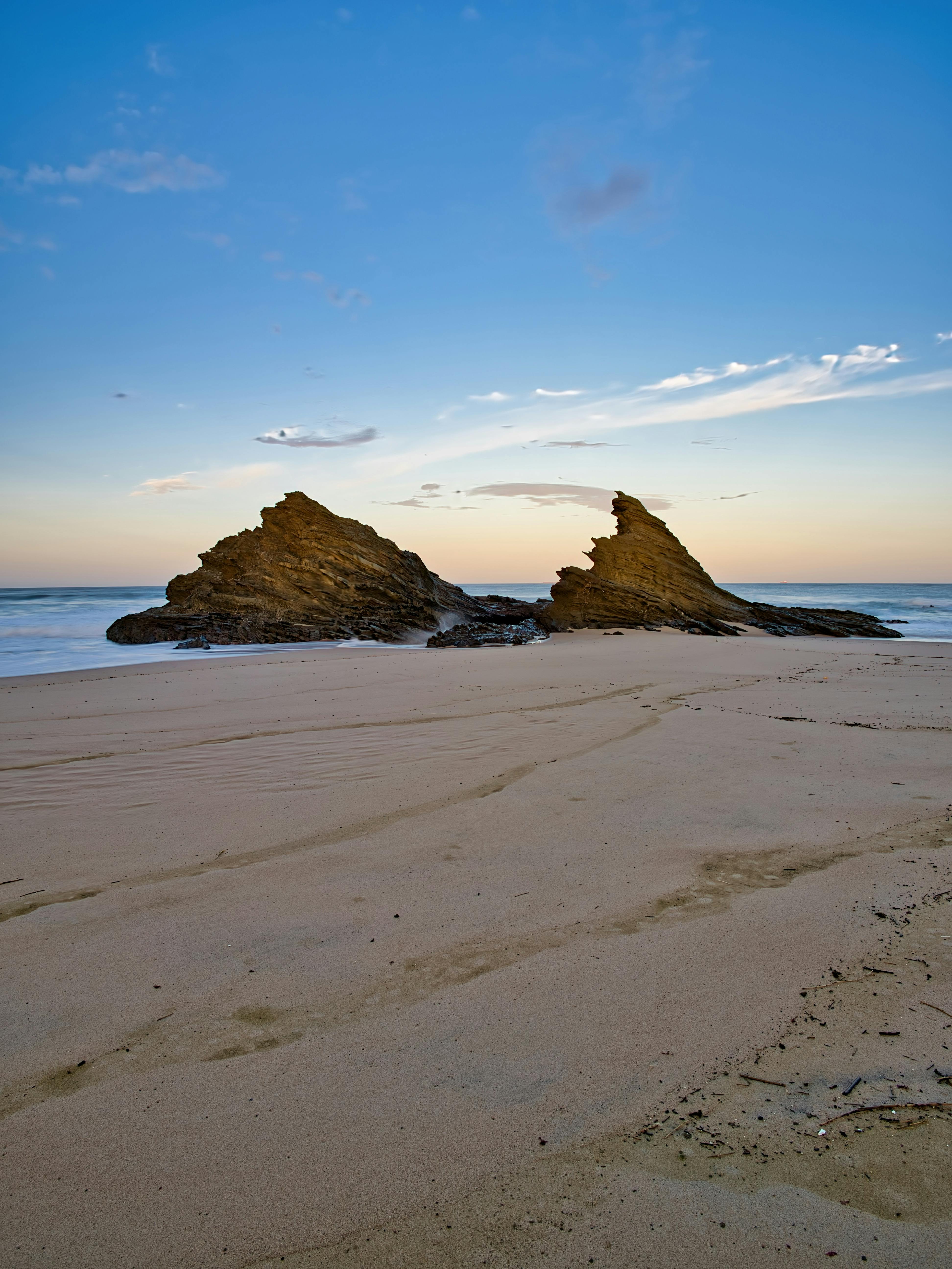 Scenic Beach with Unique Rock Formations at Sunset · Free Stock Photo