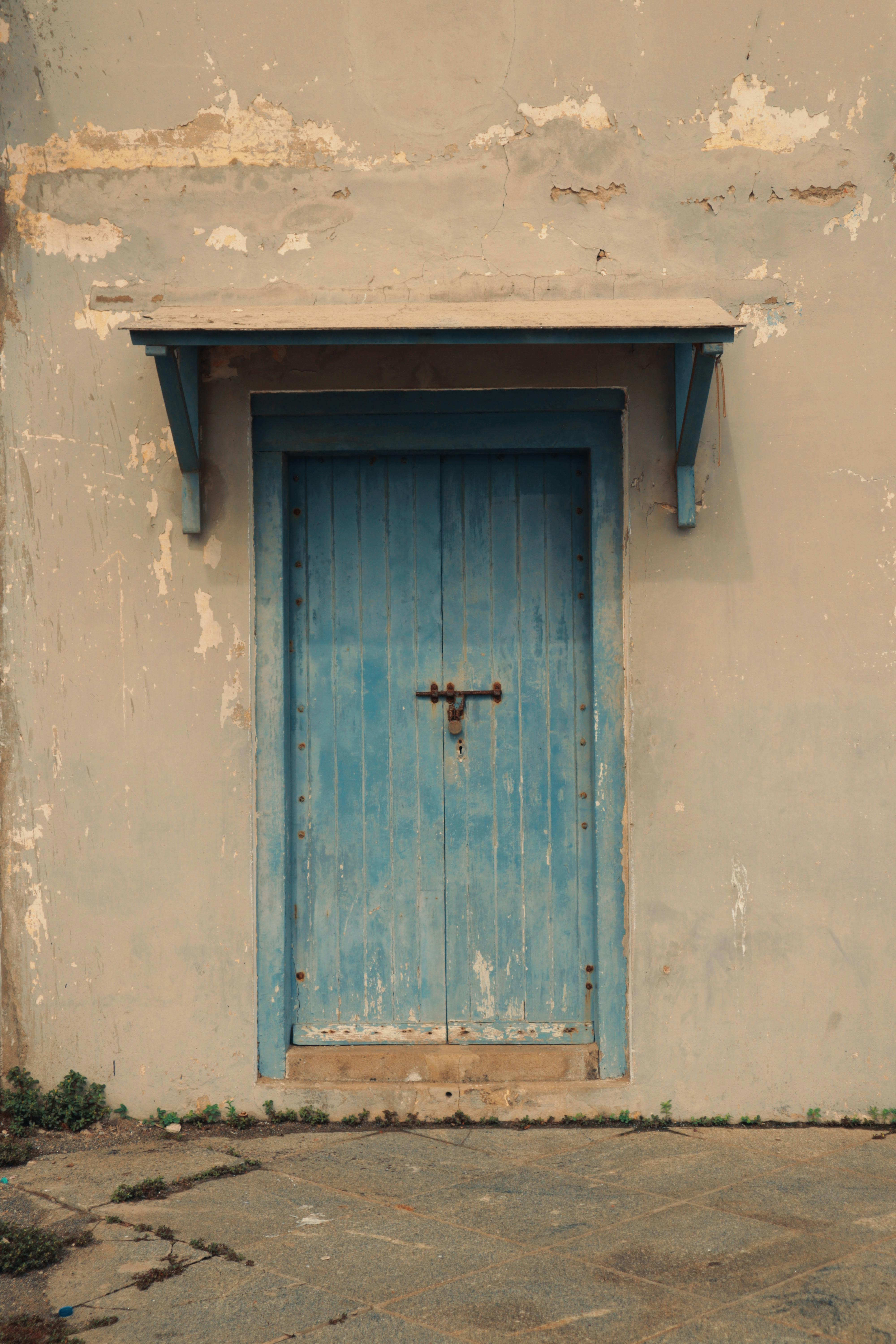 Rustic Blue Door on Weathered Wall · Free Stock Photo