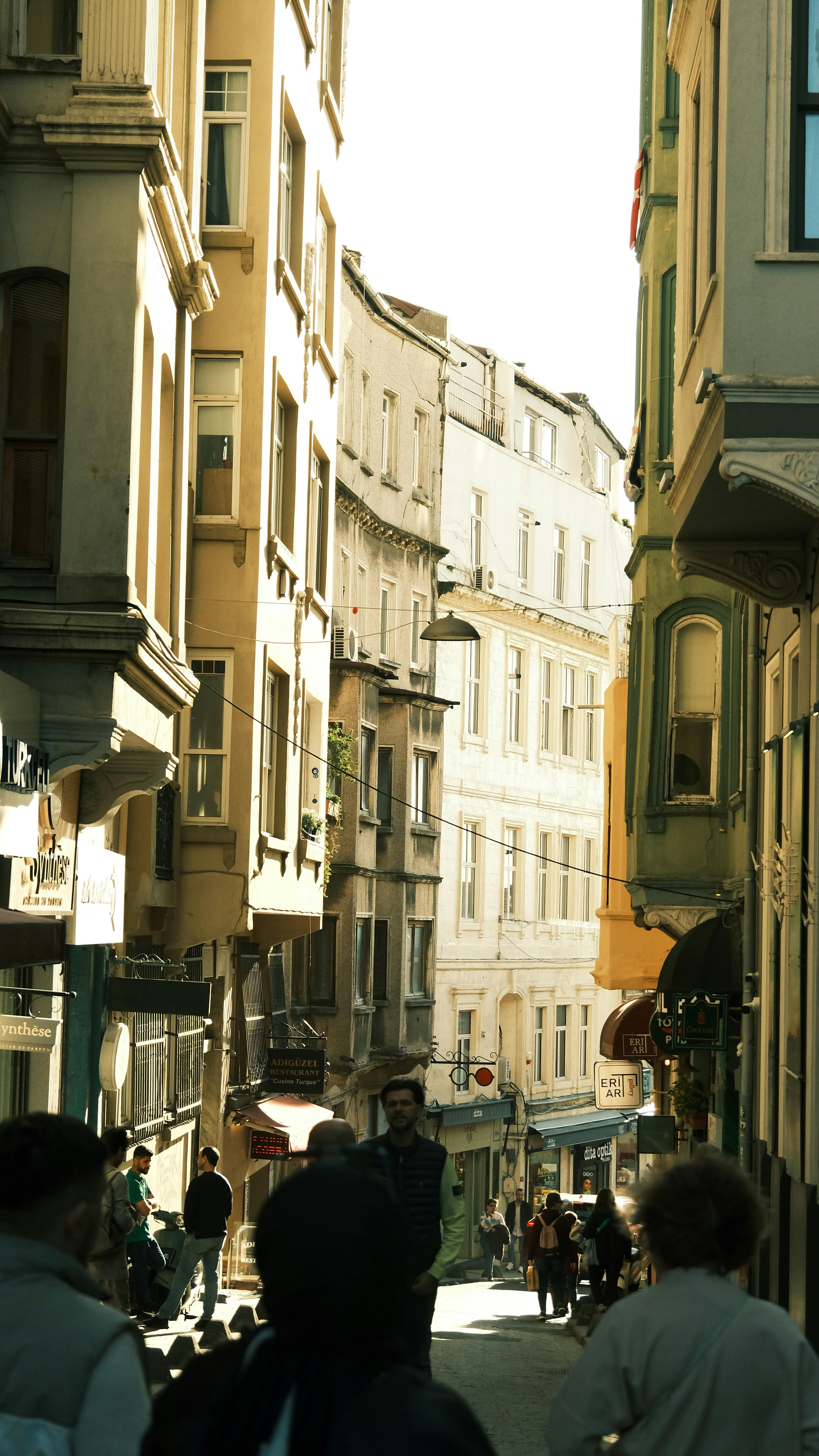 Sunlit European Street Scene with Pedestrians · Free Stock Photo