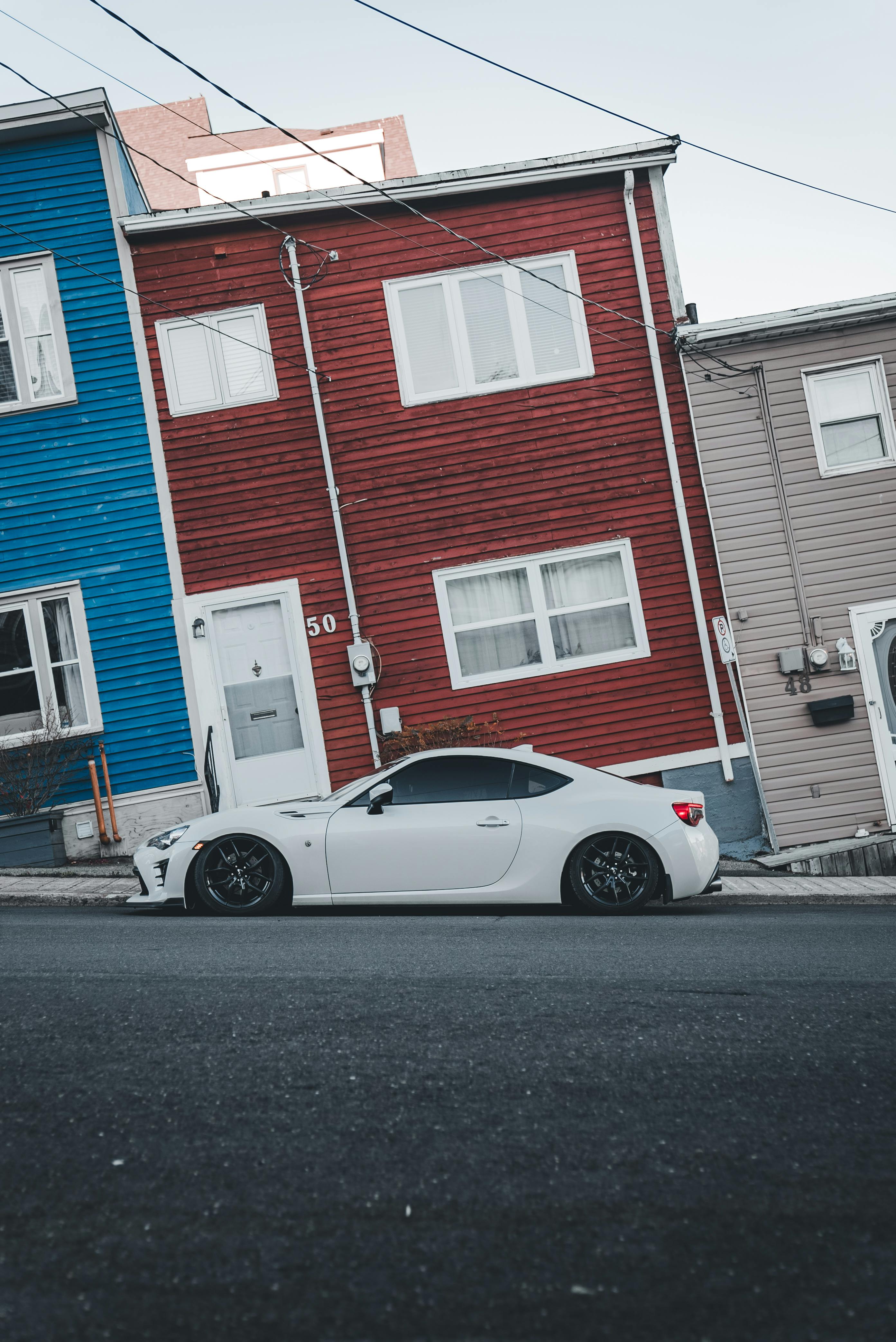 White Sports Car on Sloping Urban Street · Free Stock Photo