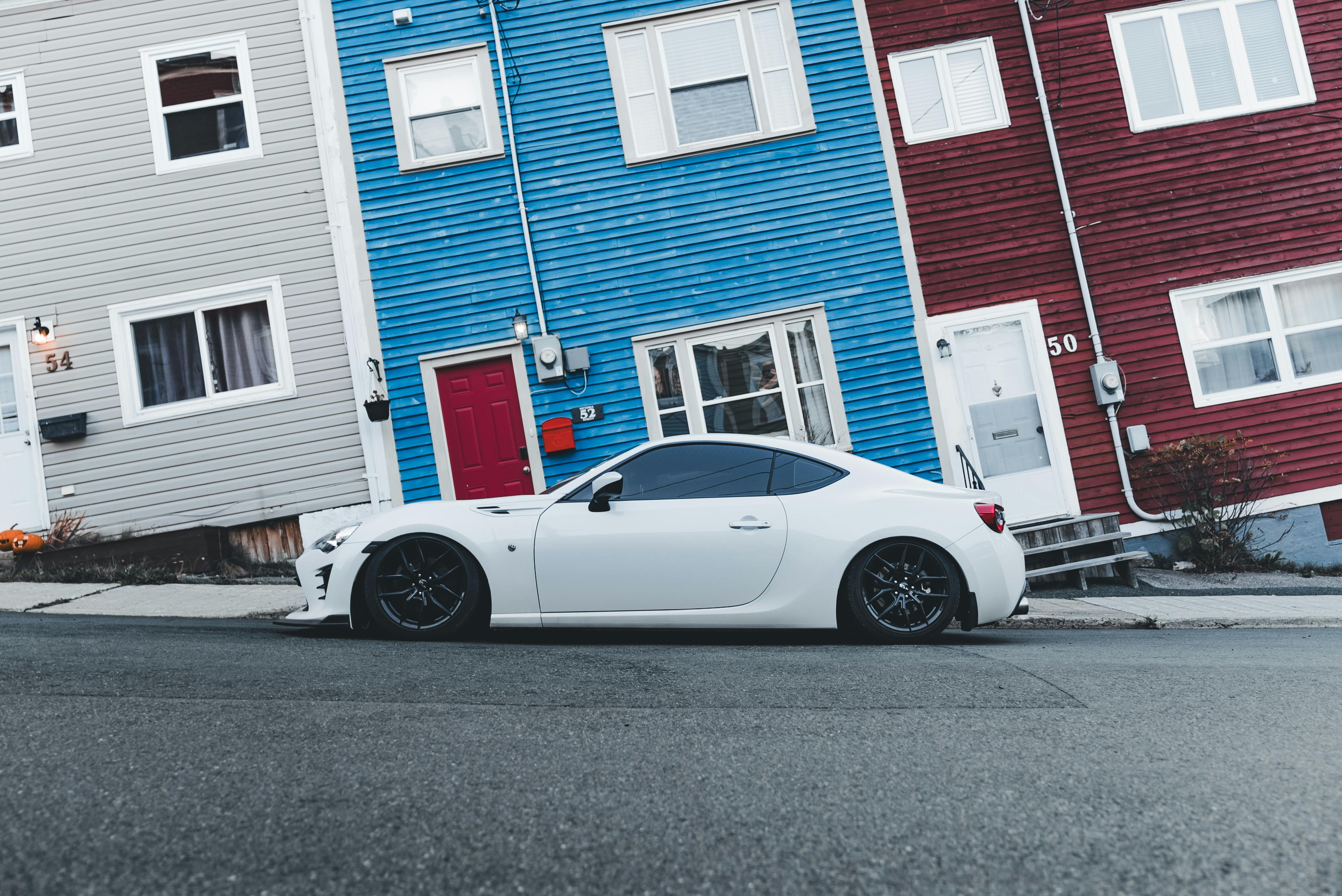 White Sports Car on Sloping Street View · Free Stock Photo