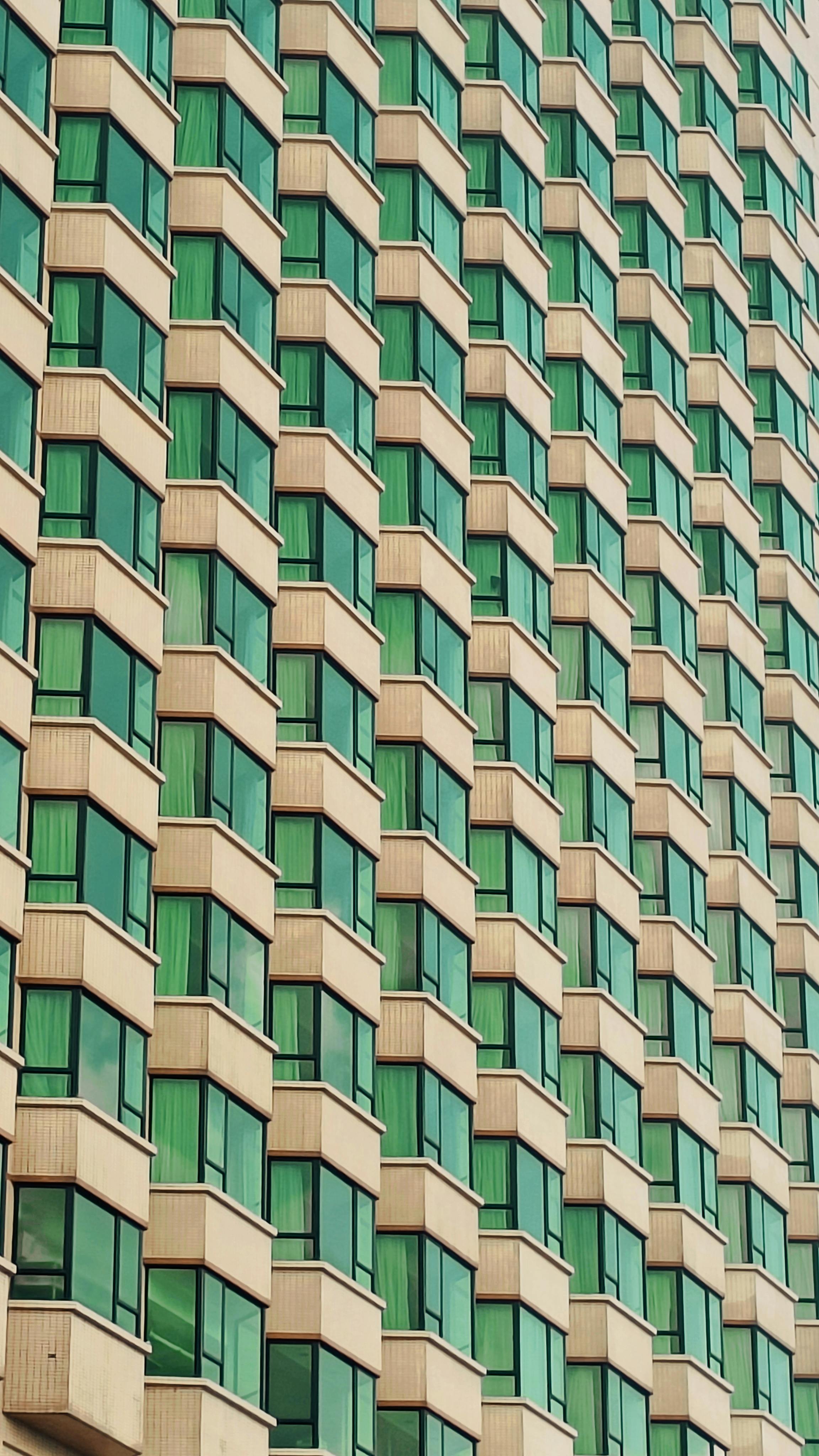 Patterned Building Facade with Geometric Windows · Free Stock Photo