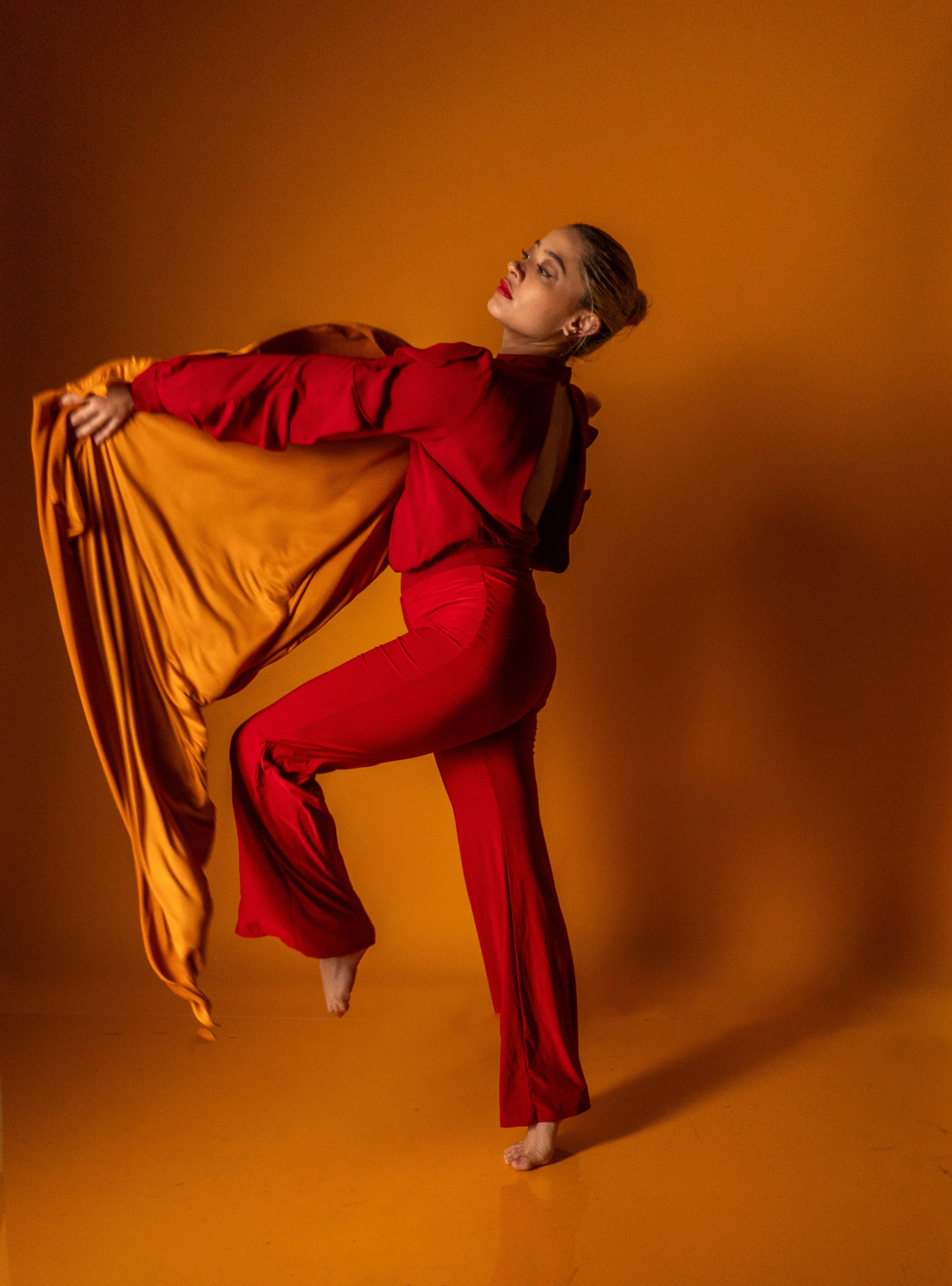 Elegant Dance Pose with Vibrant Orange Backdrop · Free Stock Photo