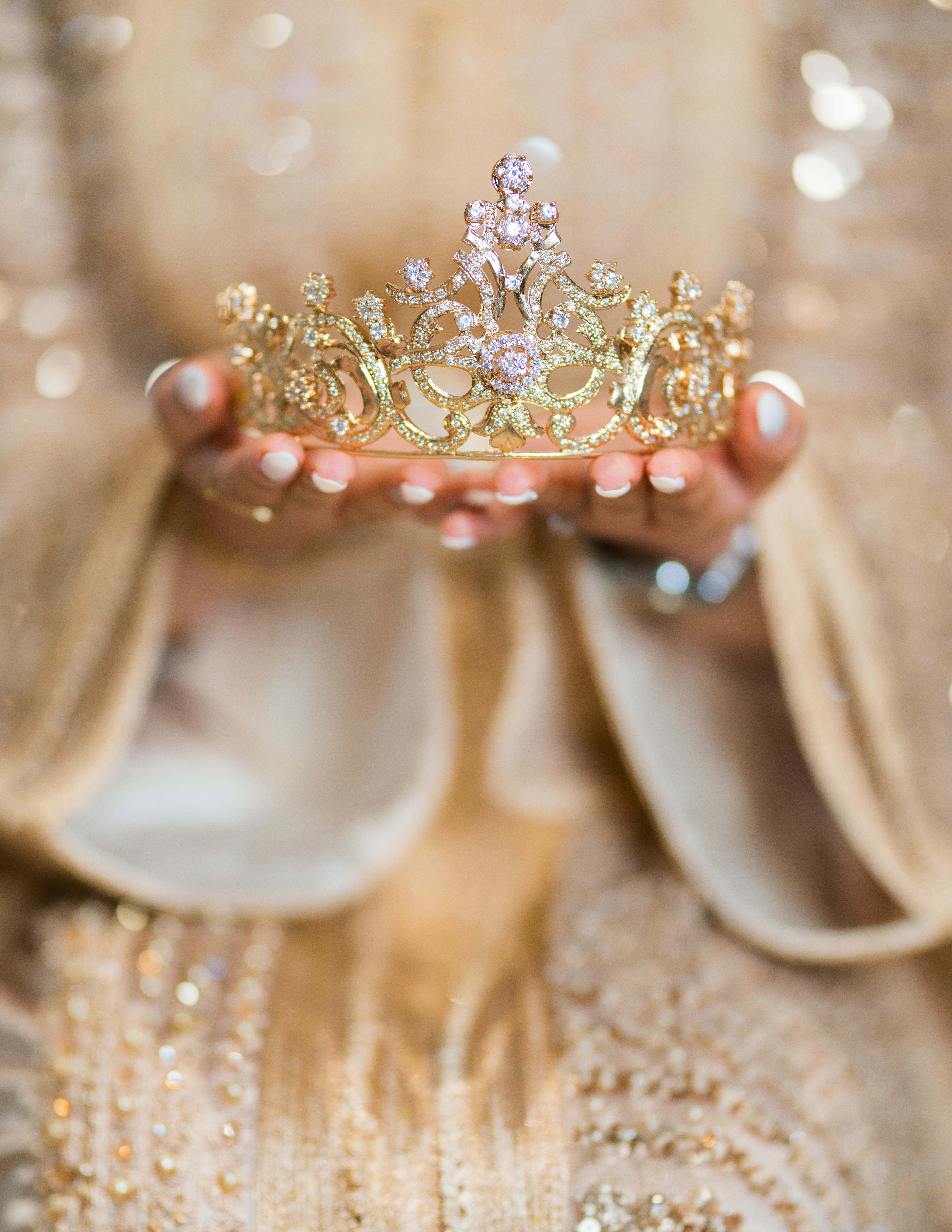 Elegante Corona De Oro En Manos Extendidas · Foto de stock gratuita