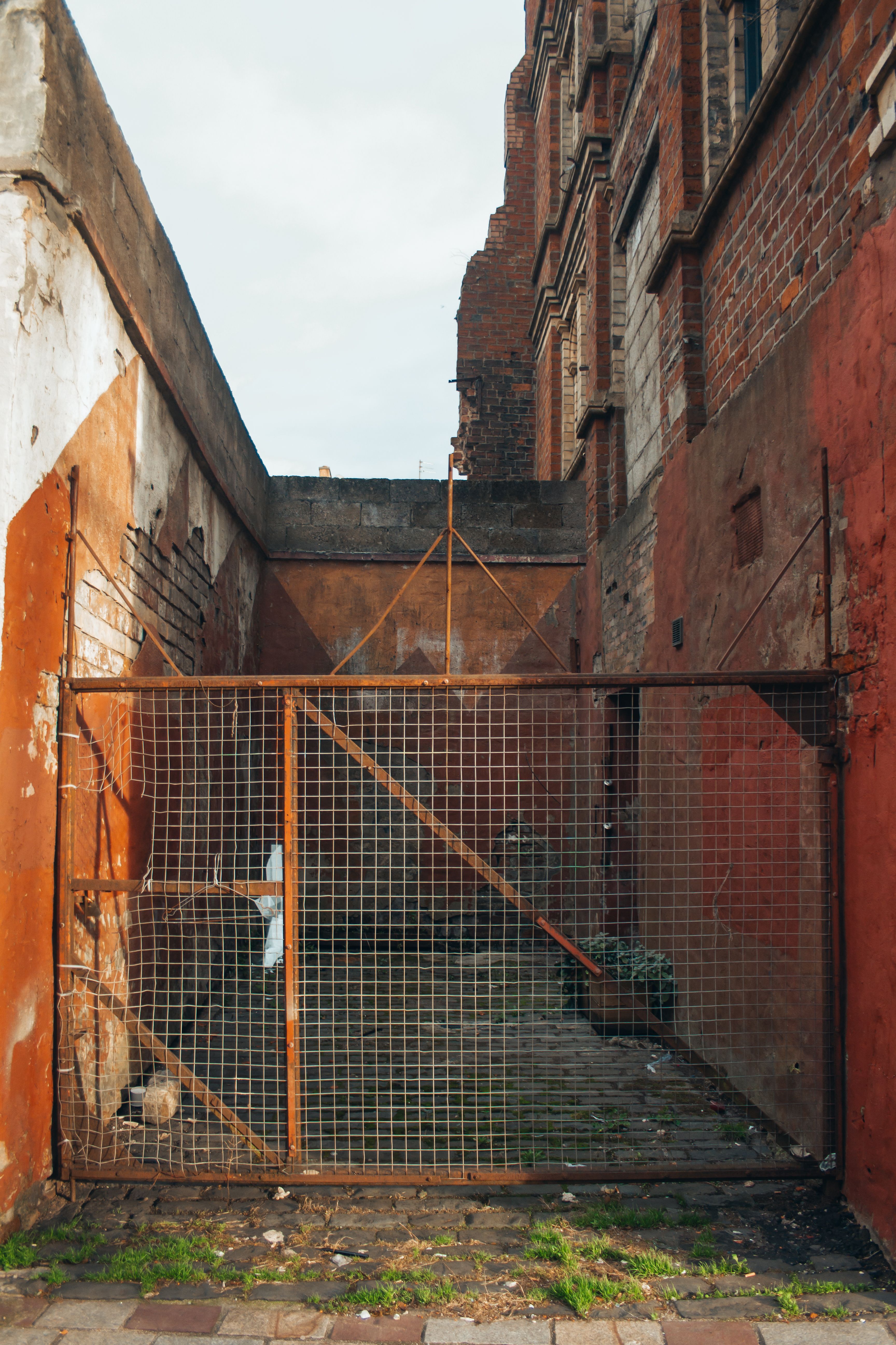 Rustic Brick Alley with Metal Gate · Free Stock Photo