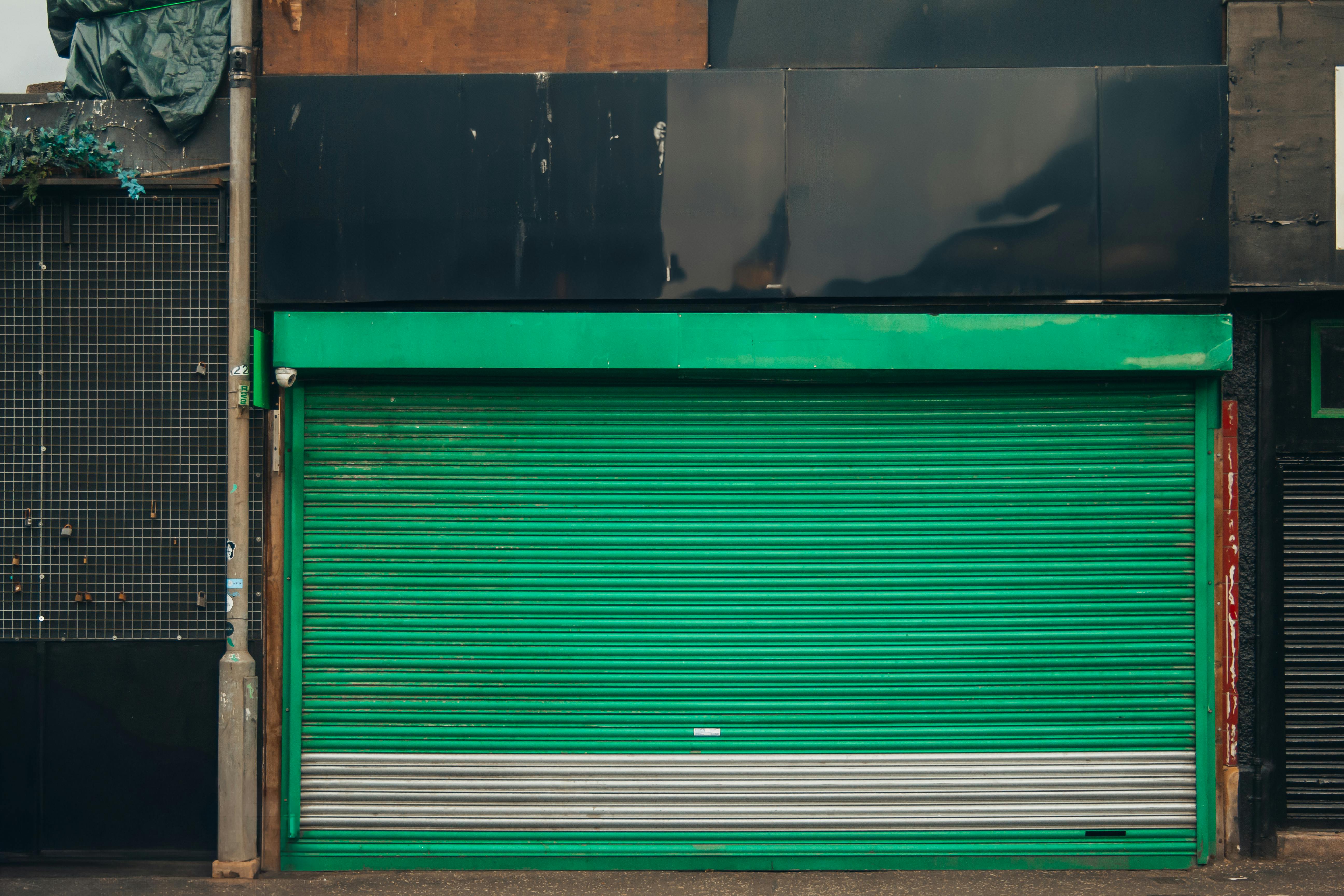 Closed Urban Storefront with Green Shutters · Free Stock Photo