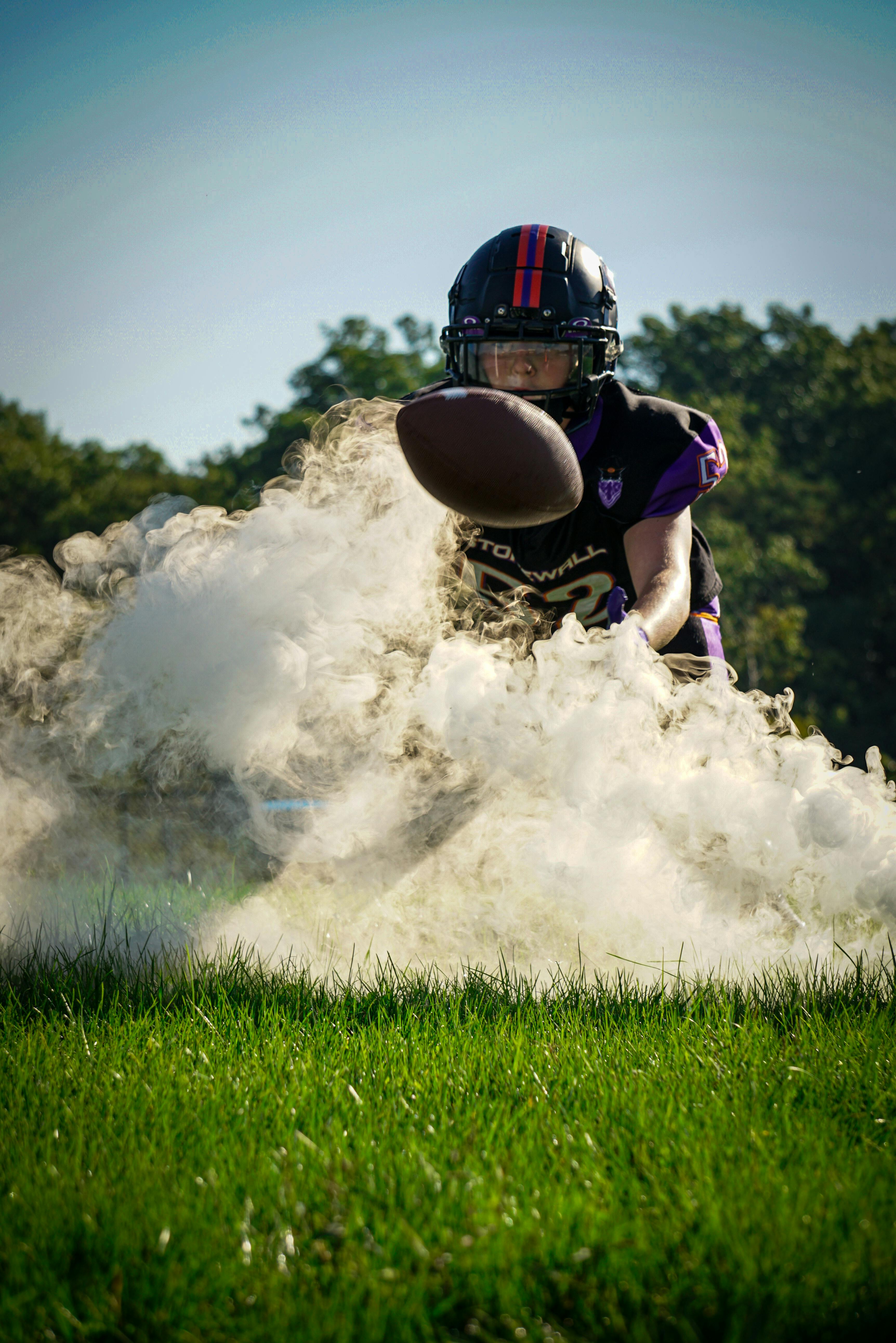 Dynamic Football Catch Amidst Smoke Outdoors · Free Stock Photo