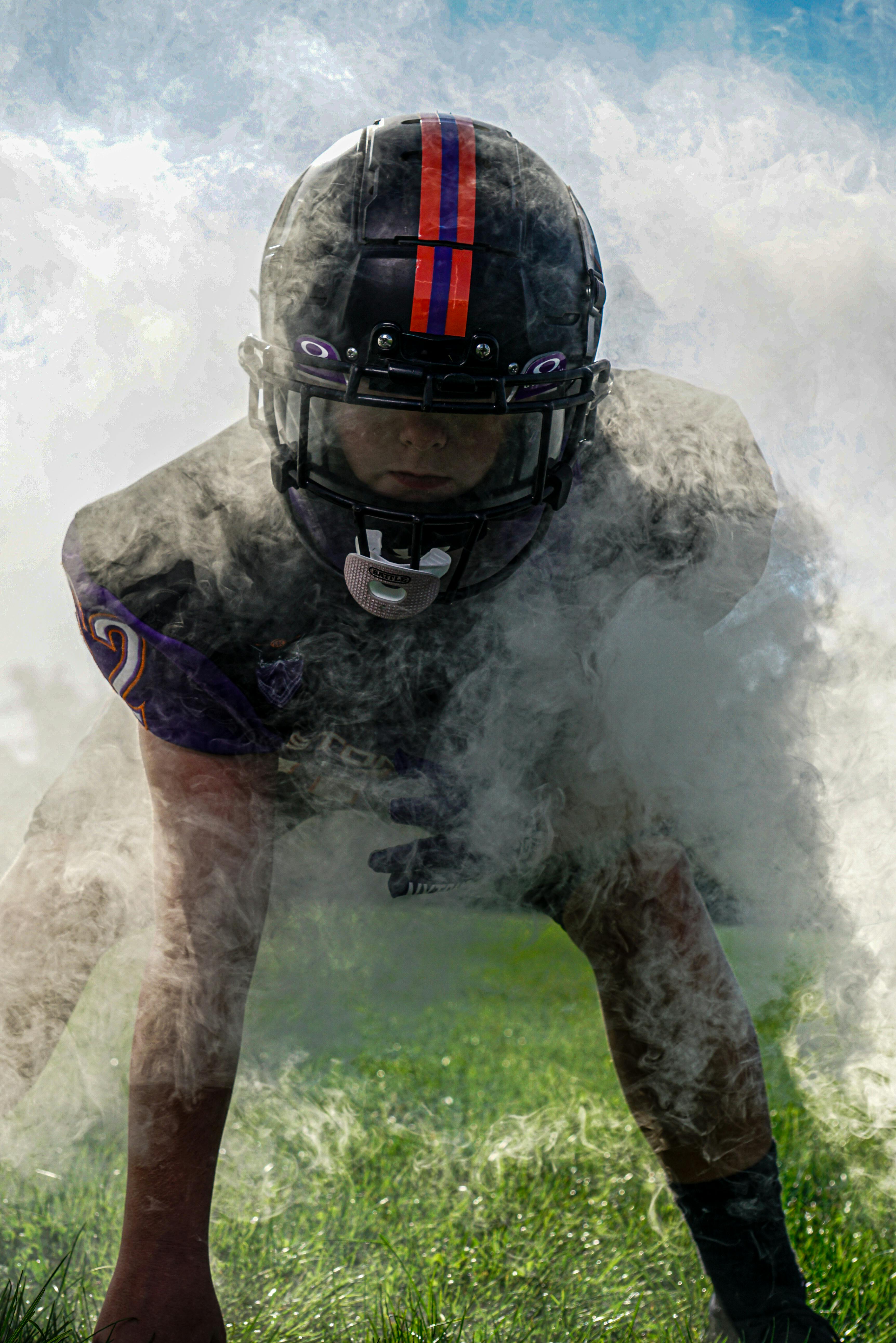 Football Player Emerging from Smoke on Field · Free Stock Photo