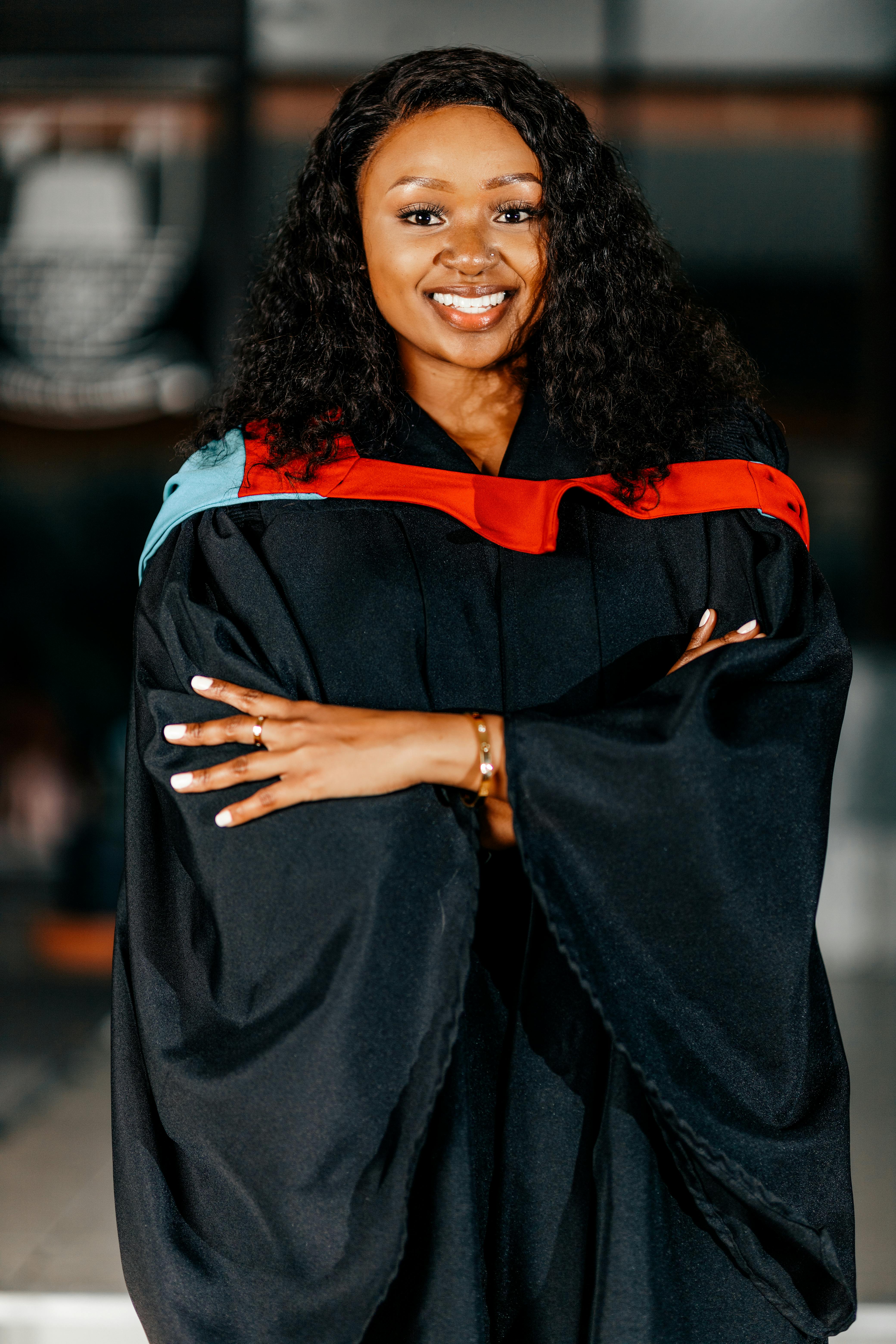 Smiling Graduate in Black Cap and Gown · Free Stock Photo