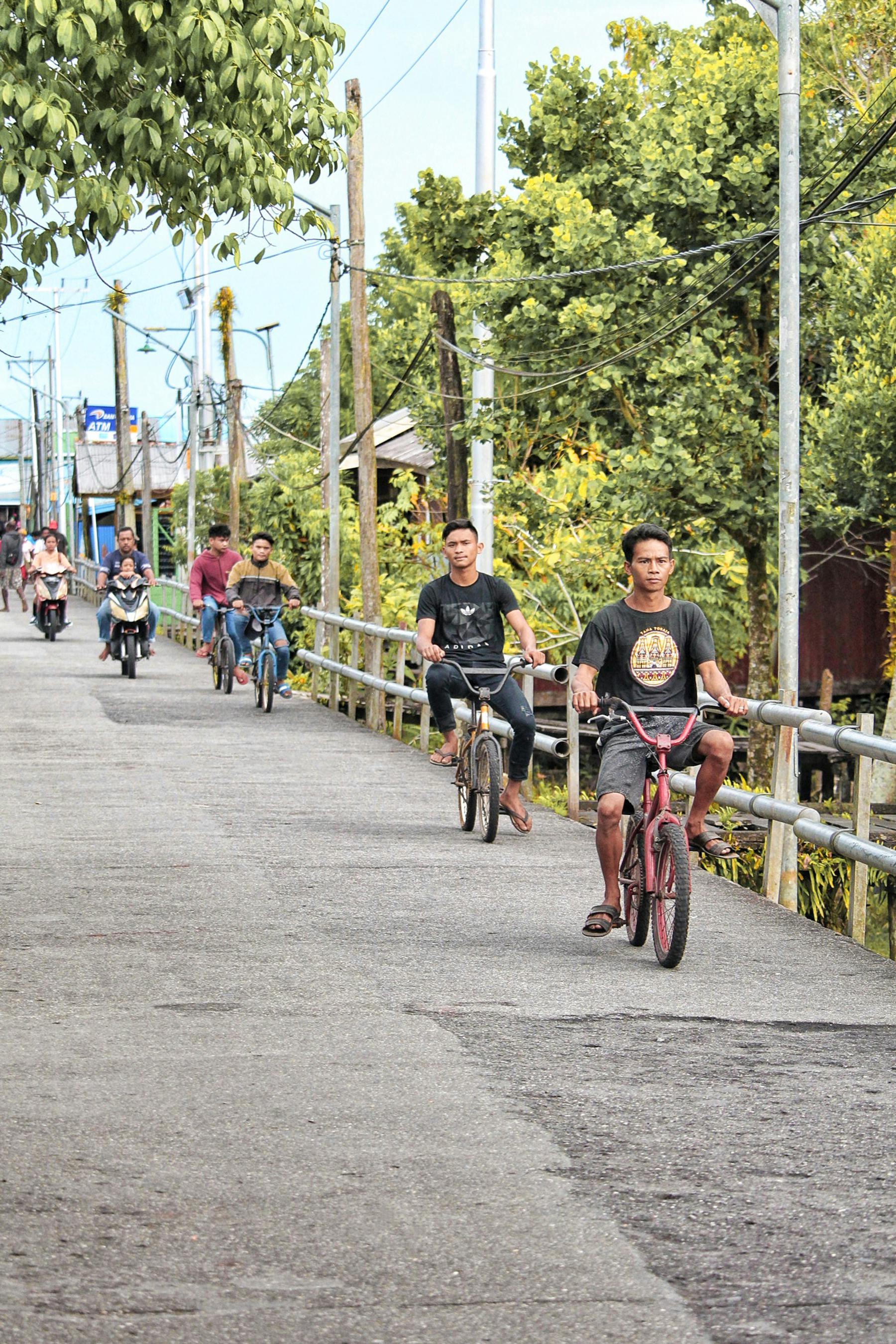 Cyclists on Rural Road in Agats, Indonesia · Free Stock Photo