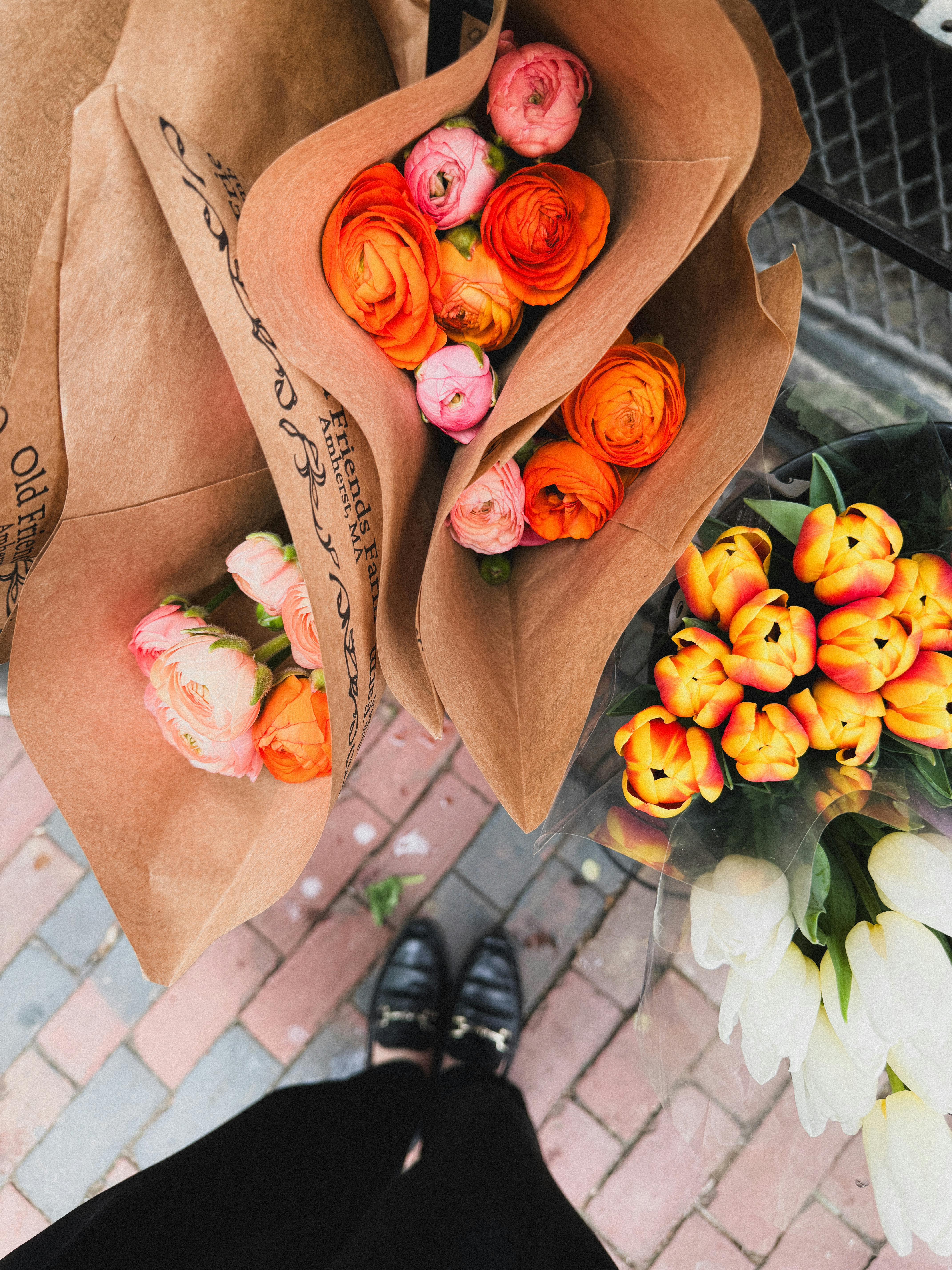 Colorful flower bouquets on brick pavement · Free Stock Photo
