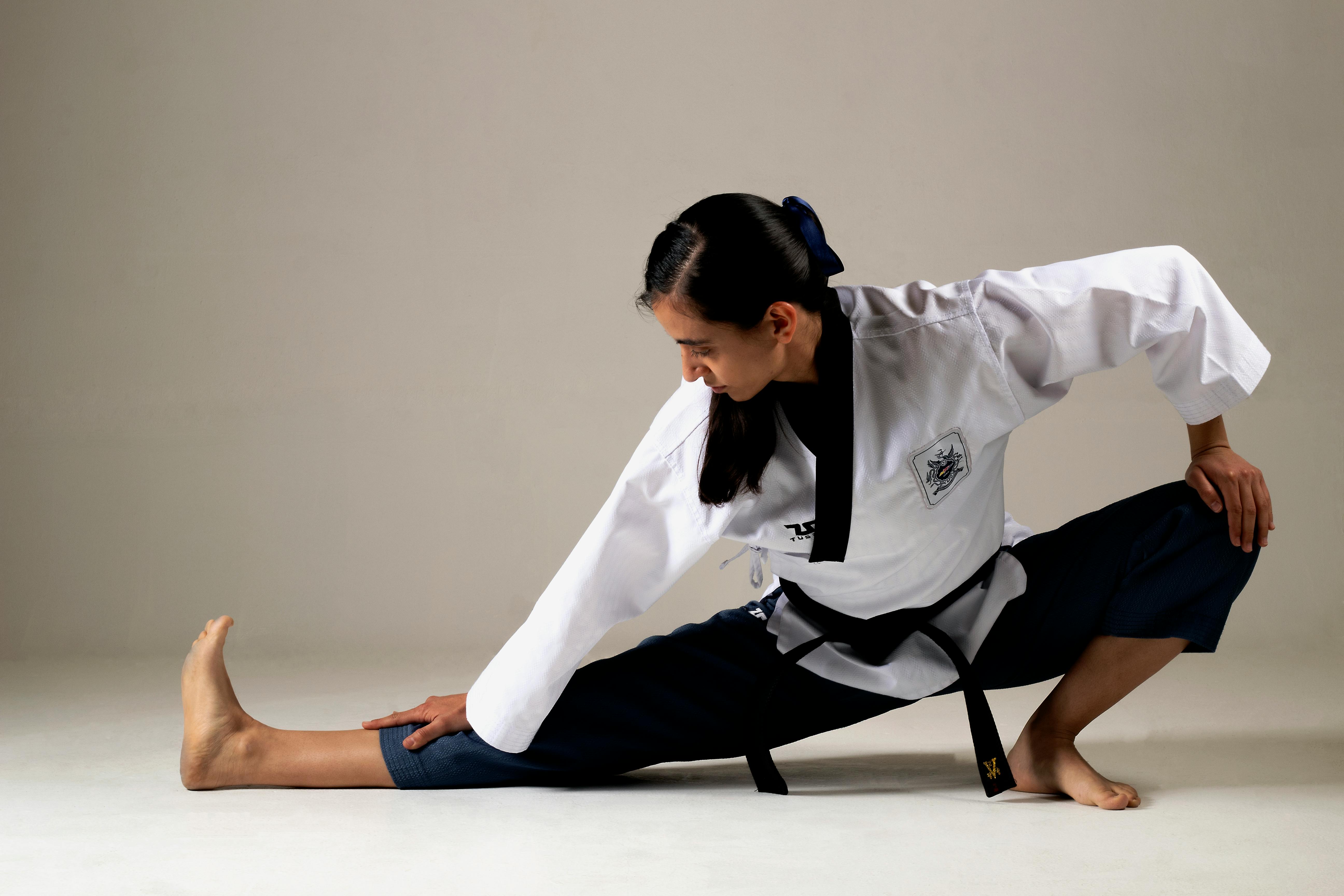 Martial Artist Stretching in Taekwondo Uniform · Free Stock Photo