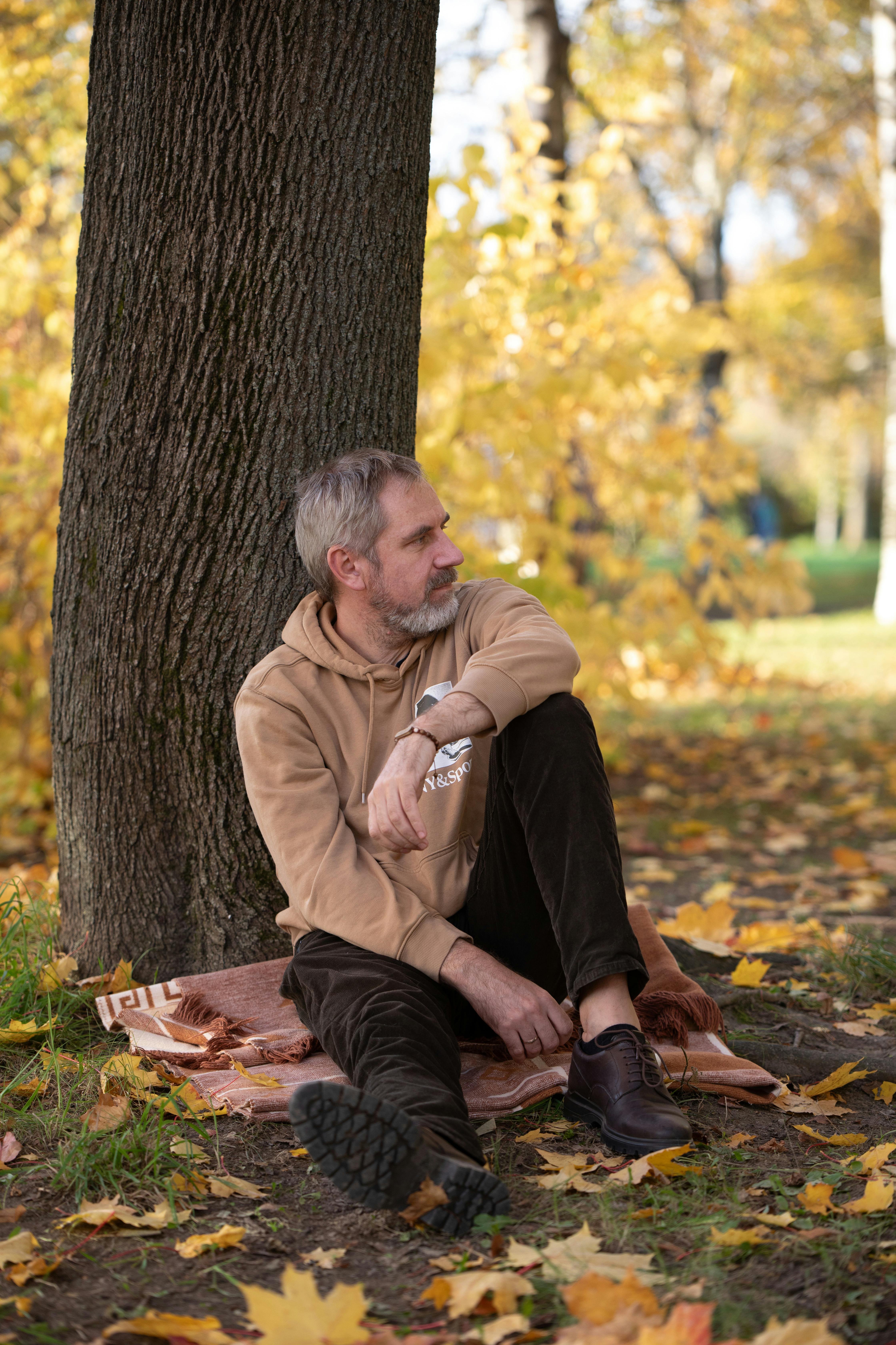 Man Relaxing Under Tree in Autumn Park · Free Stock Photo