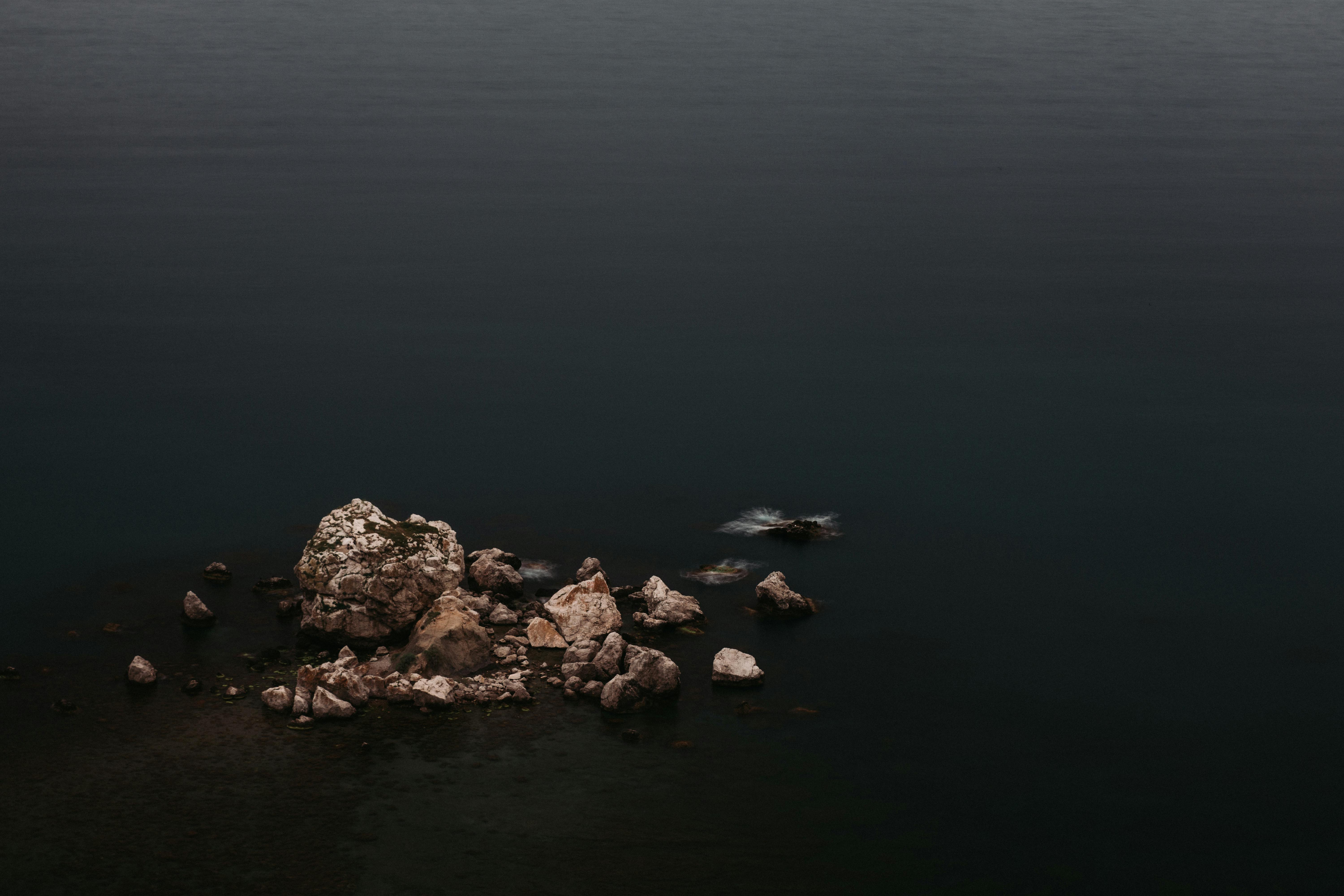 Brown Rocks on Body of Water · Free Stock Photo