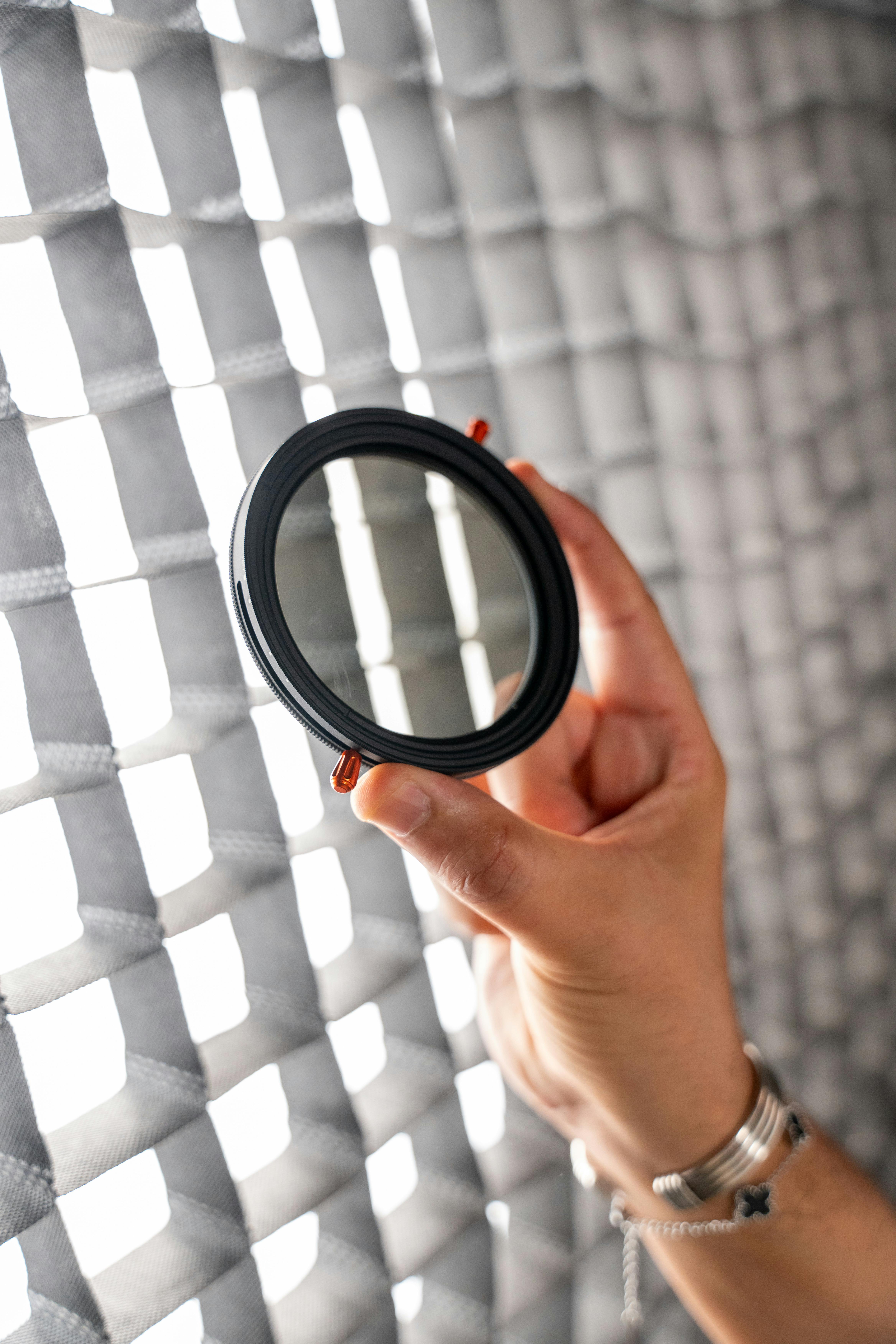 Hand Holding Camera Lens Filter Against Textured Background · Free ...
