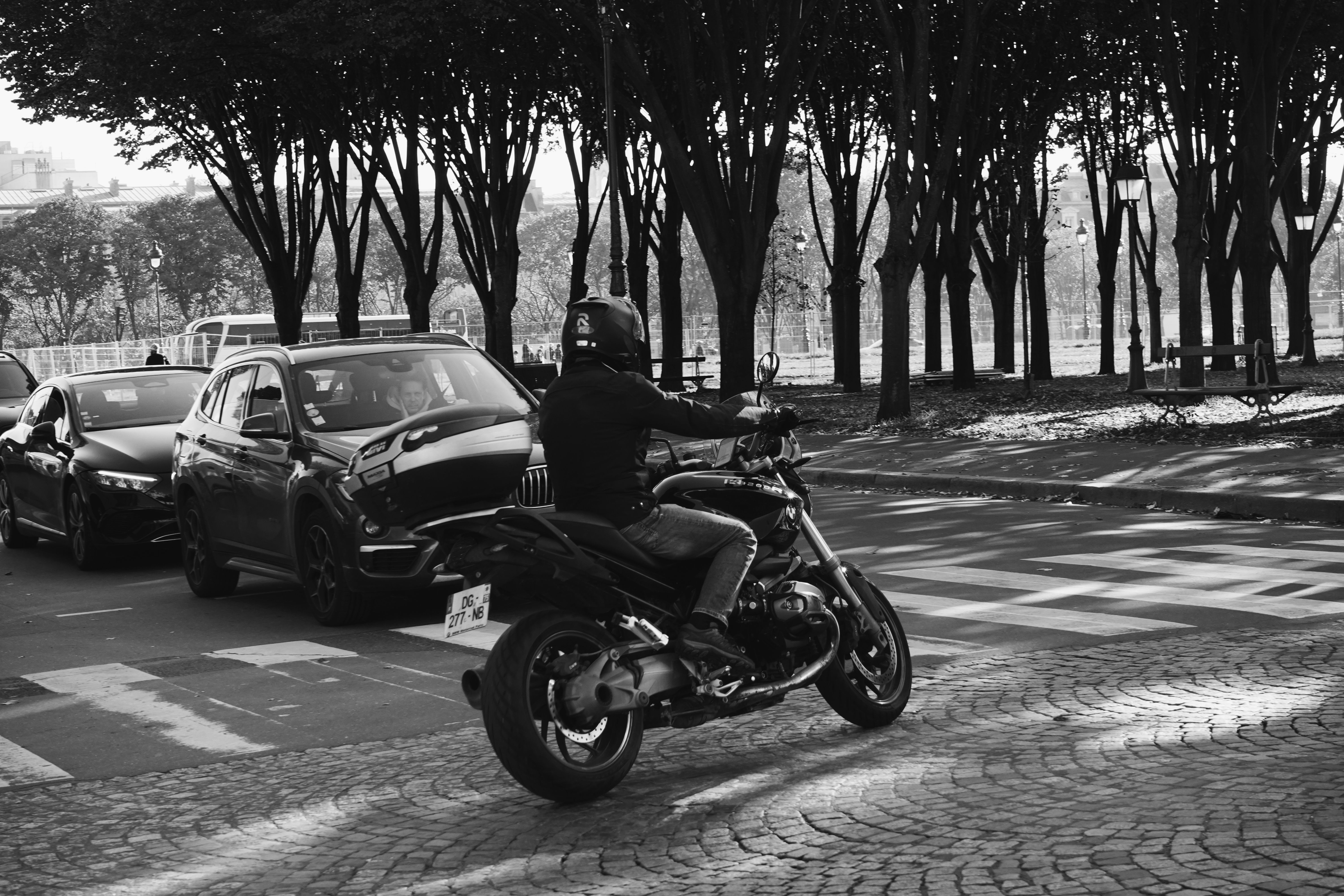 Motociclista Conduciendo Por Una Calle Arbolada De La Ciudad · Foto de ...