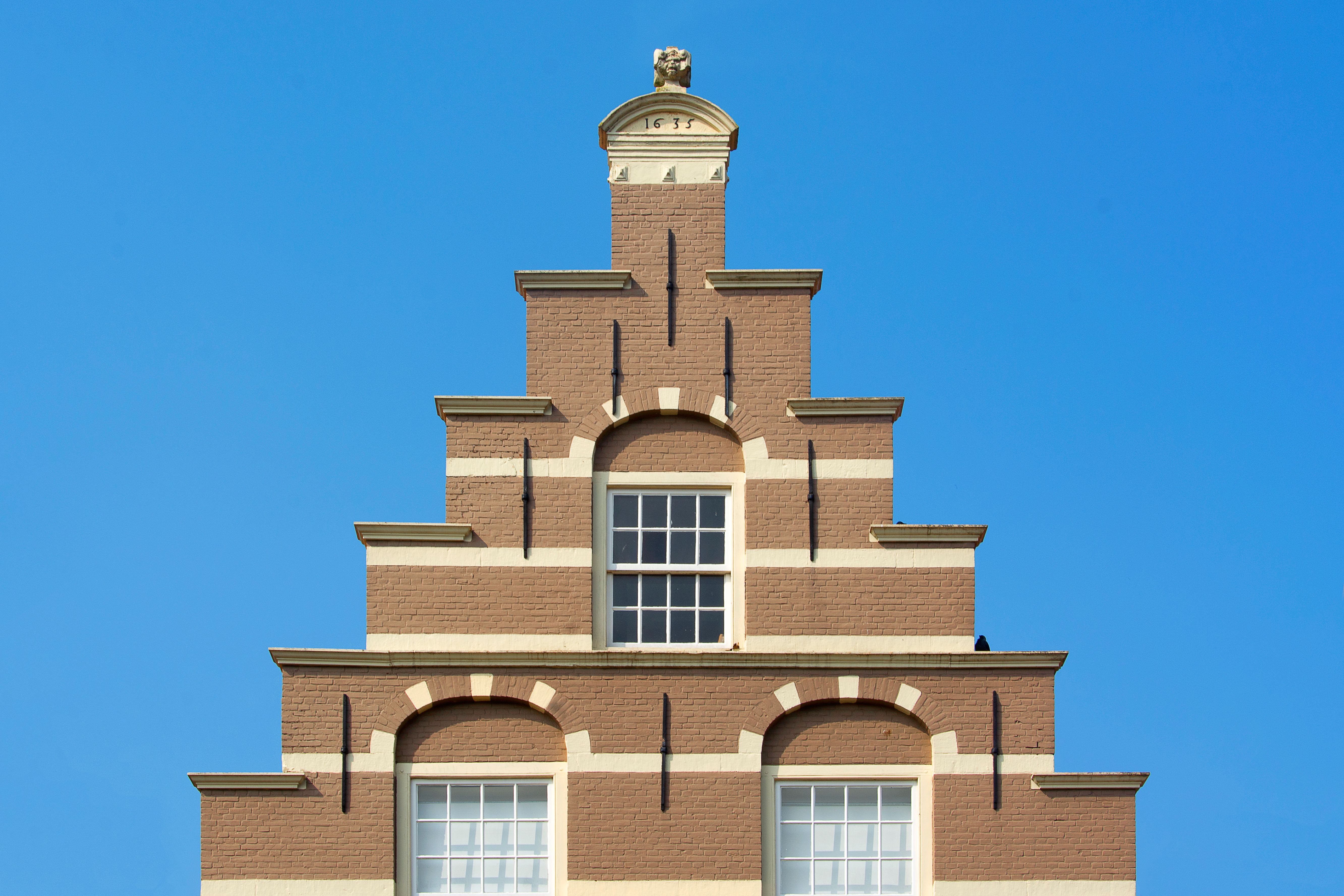 Historic Stepped Gable House Facade against Blue Sky · Free Stock Photo