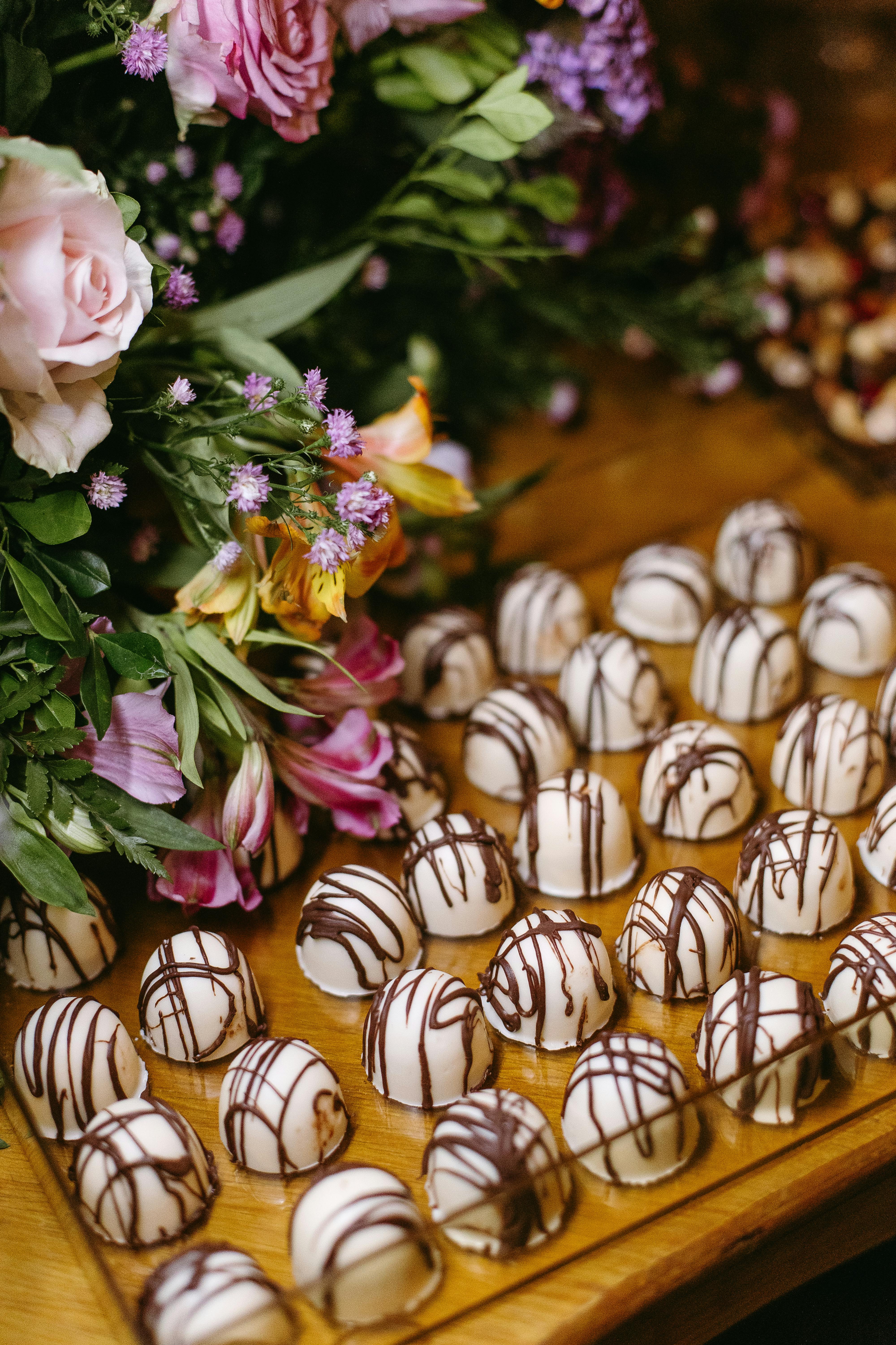 Elegant Chocolate Truffles with Floral Arrangement · Free Stock Photo