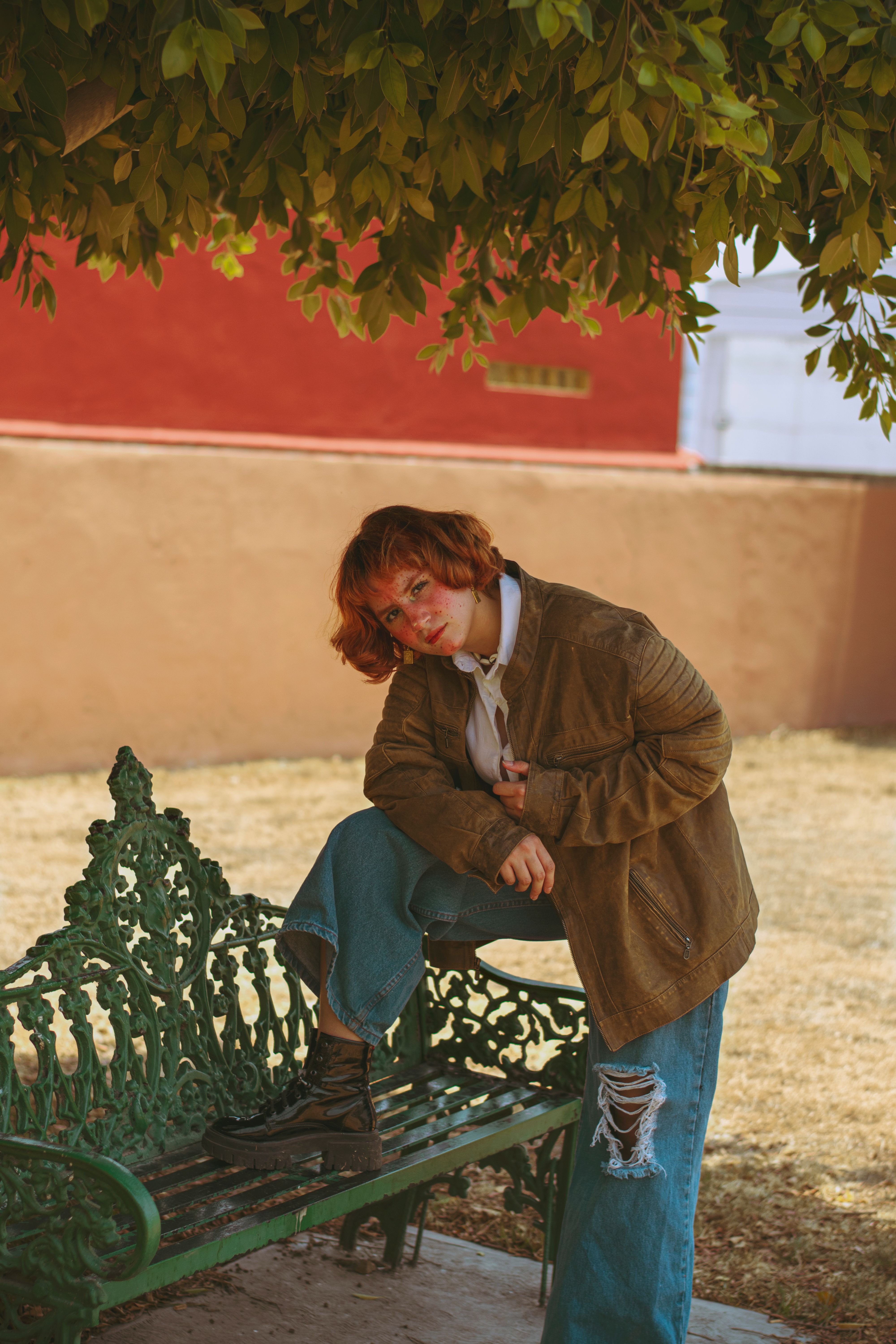 Casual Youth Posing on Antique Bench Outdoors · Free Stock Photo