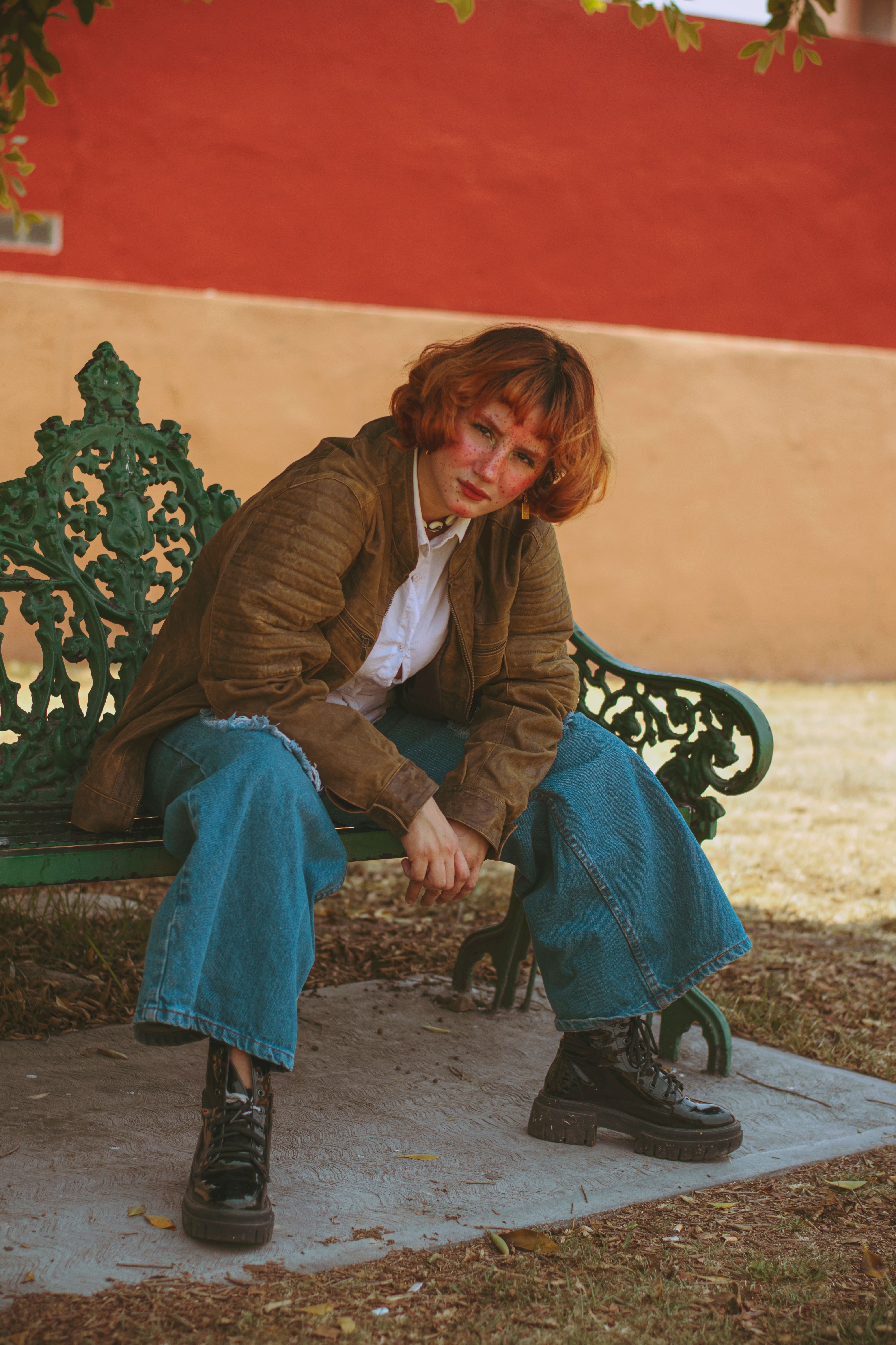 Young Person Sitting on Ornate Outdoor Bench · Free Stock Photo