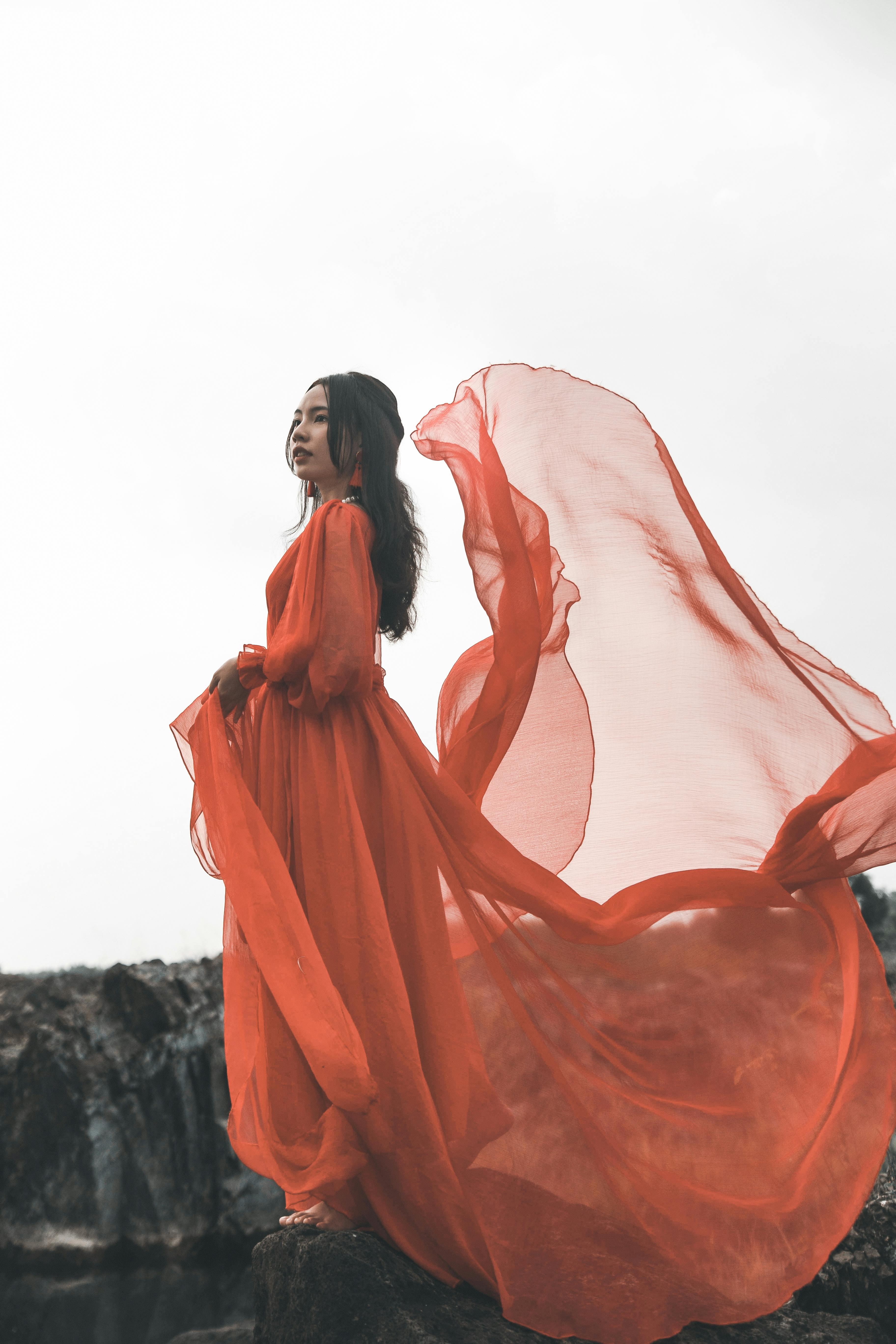 Elegant Woman in Flowing Red Dress Outdoors · Free Stock Photo