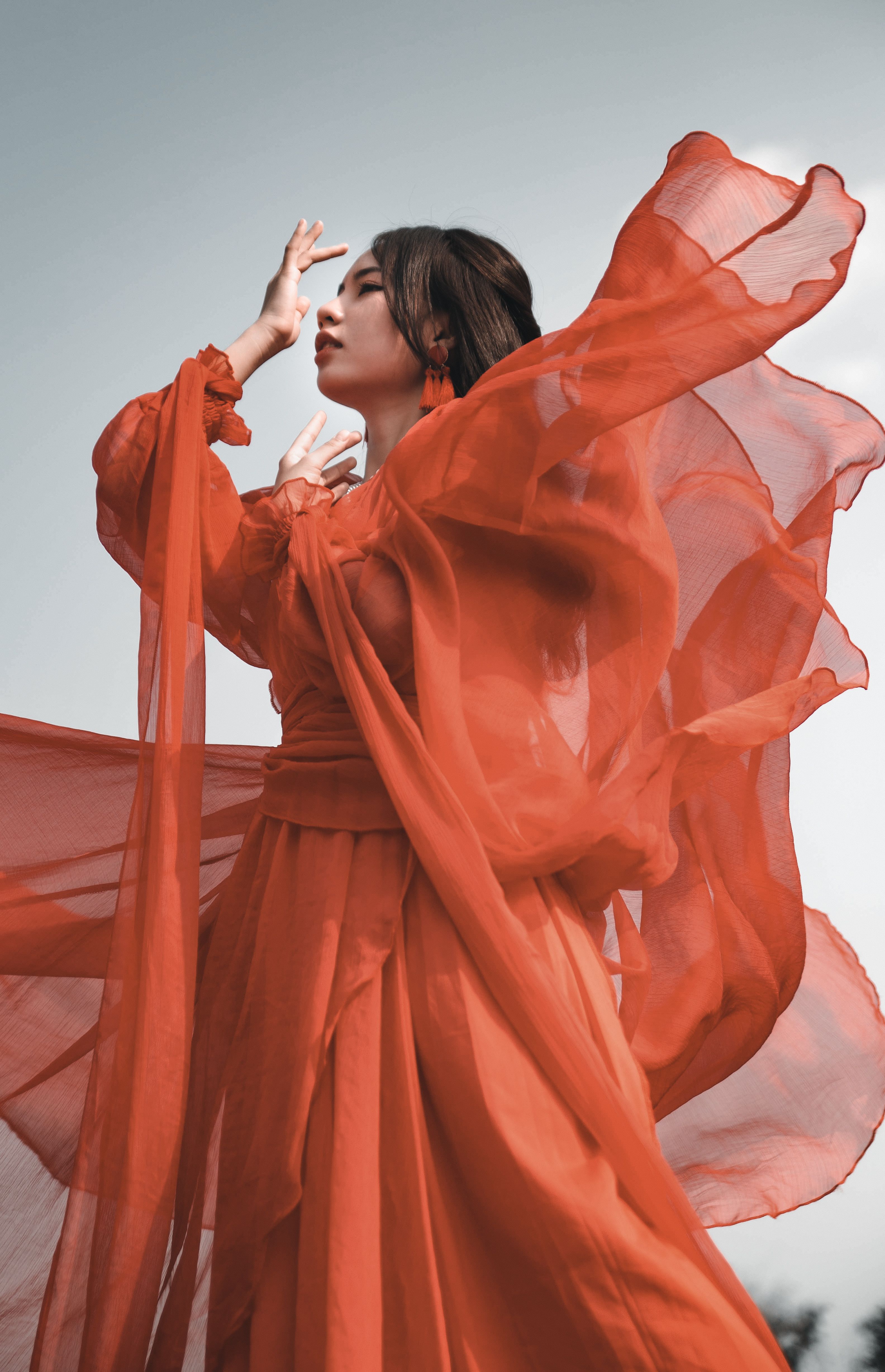 Elegant Woman in Flowing Red Dress Outdoors · Free Stock Photo