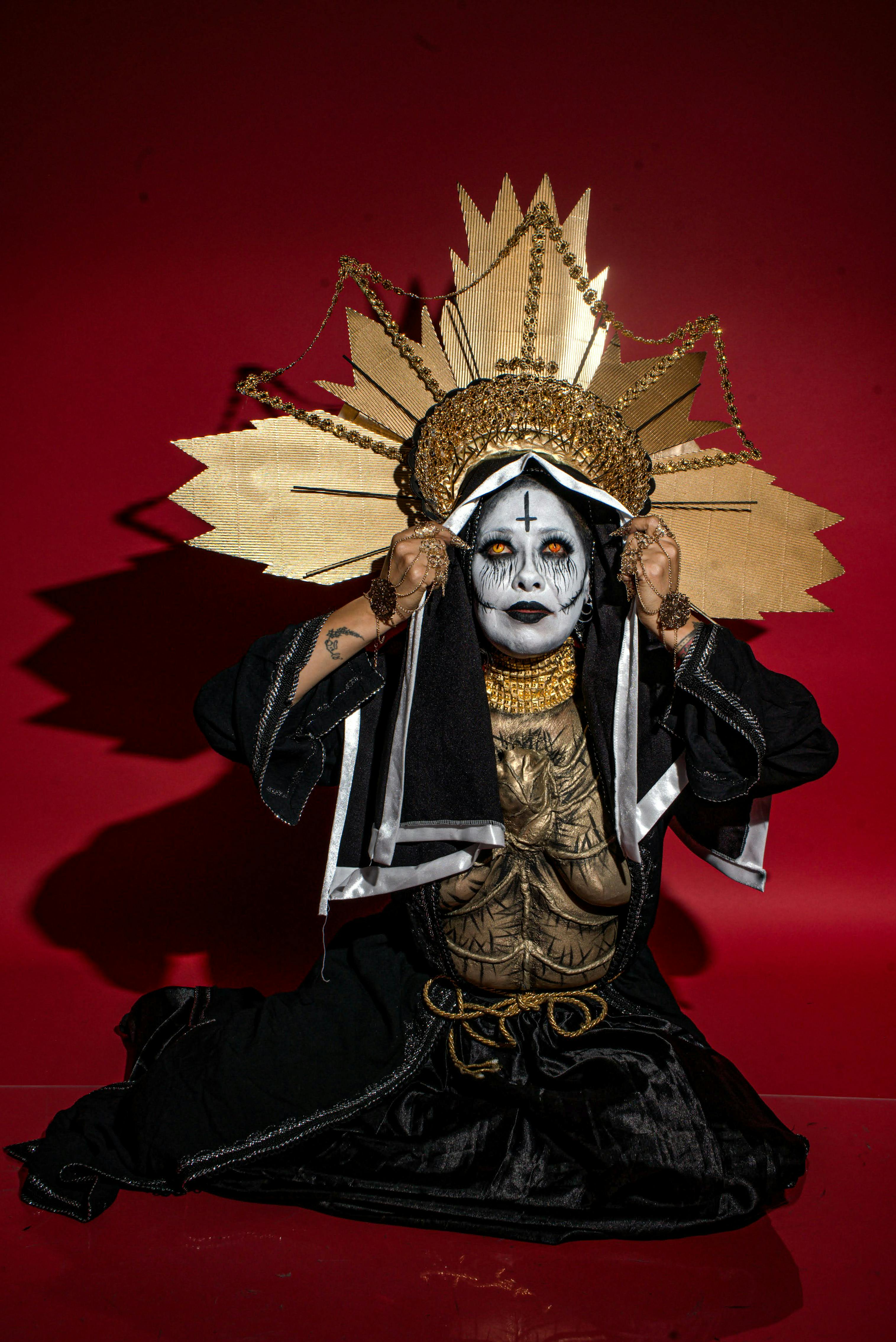Dramatic Cultural Costume Portrait on Red Background · Free Stock Photo