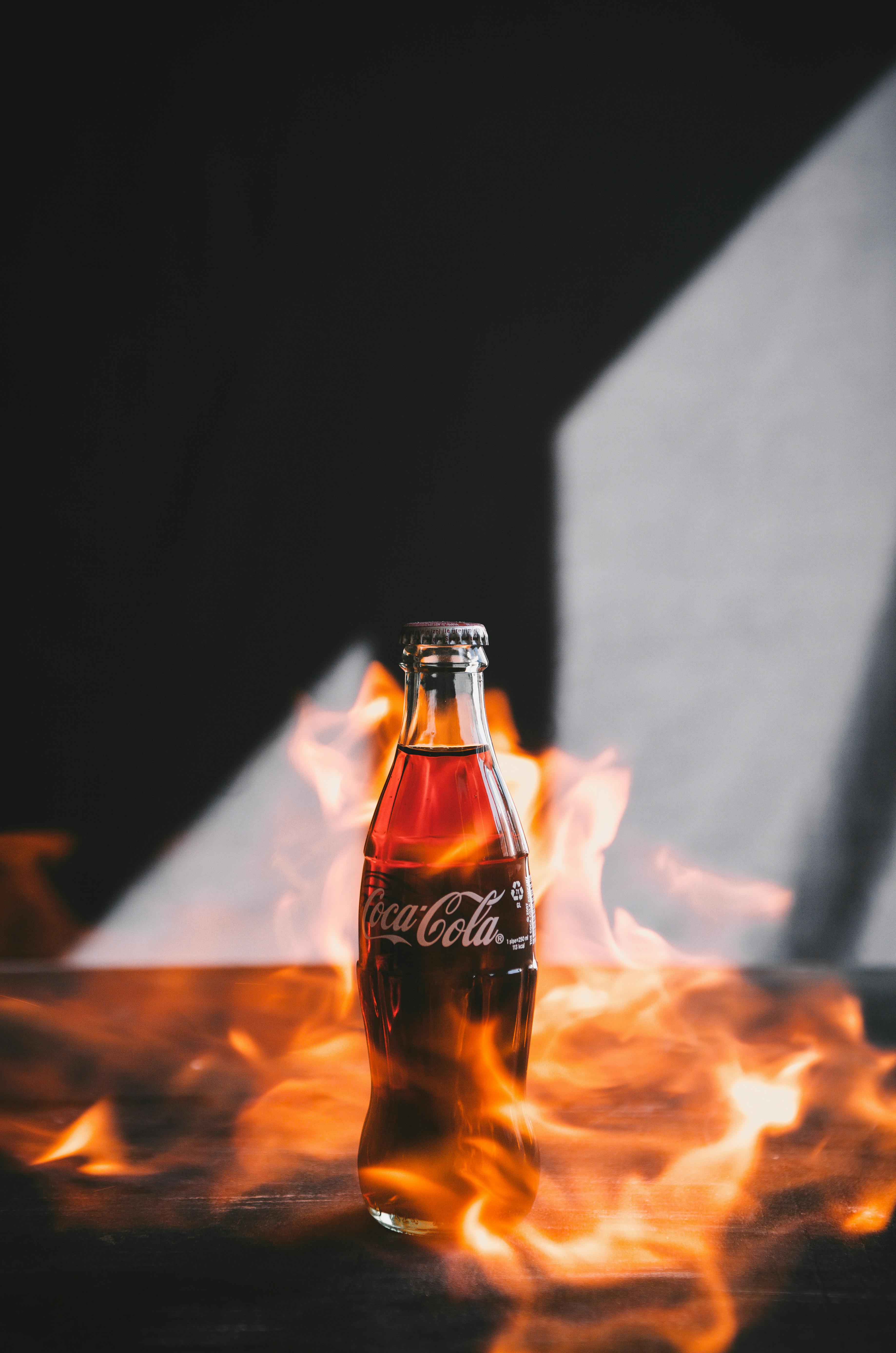Dynamic Coca-Cola Bottle Surrounded by Flames · Free Stock Photo