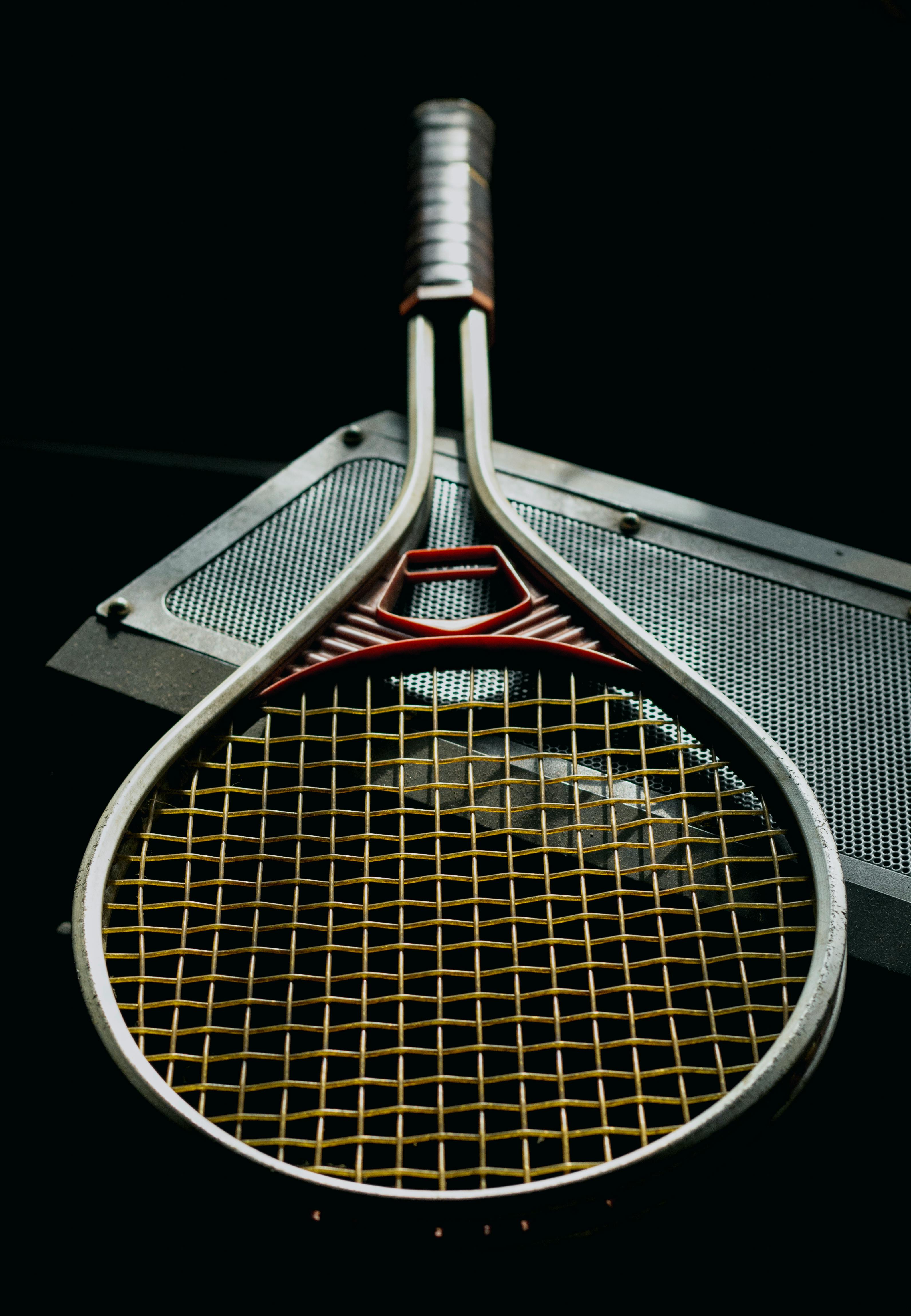 Close-up Shot of Tennis Racket on Dark Background · Free Stock Photo