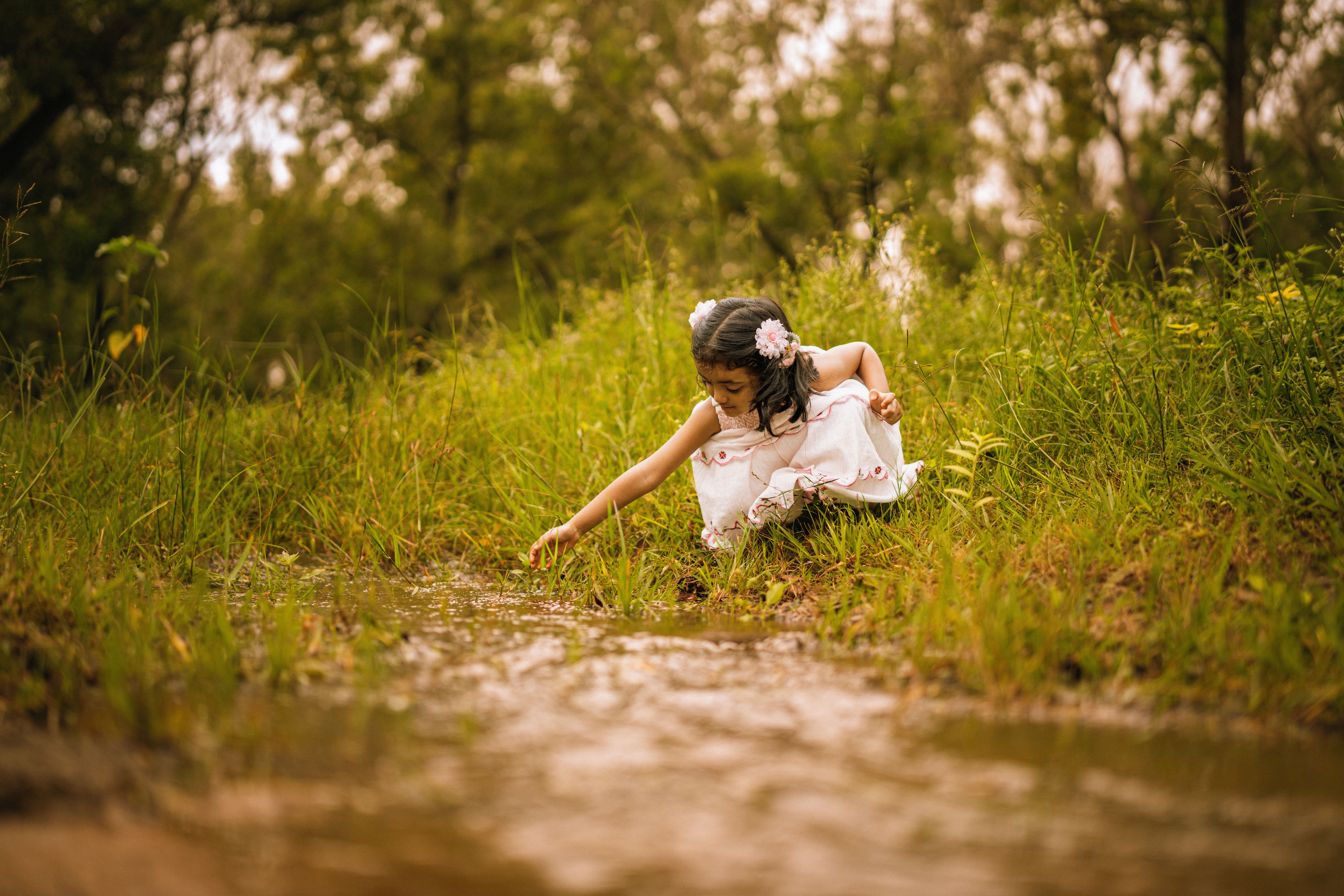 Child Playing by Stream in Lush Greenery · Free Stock Photo