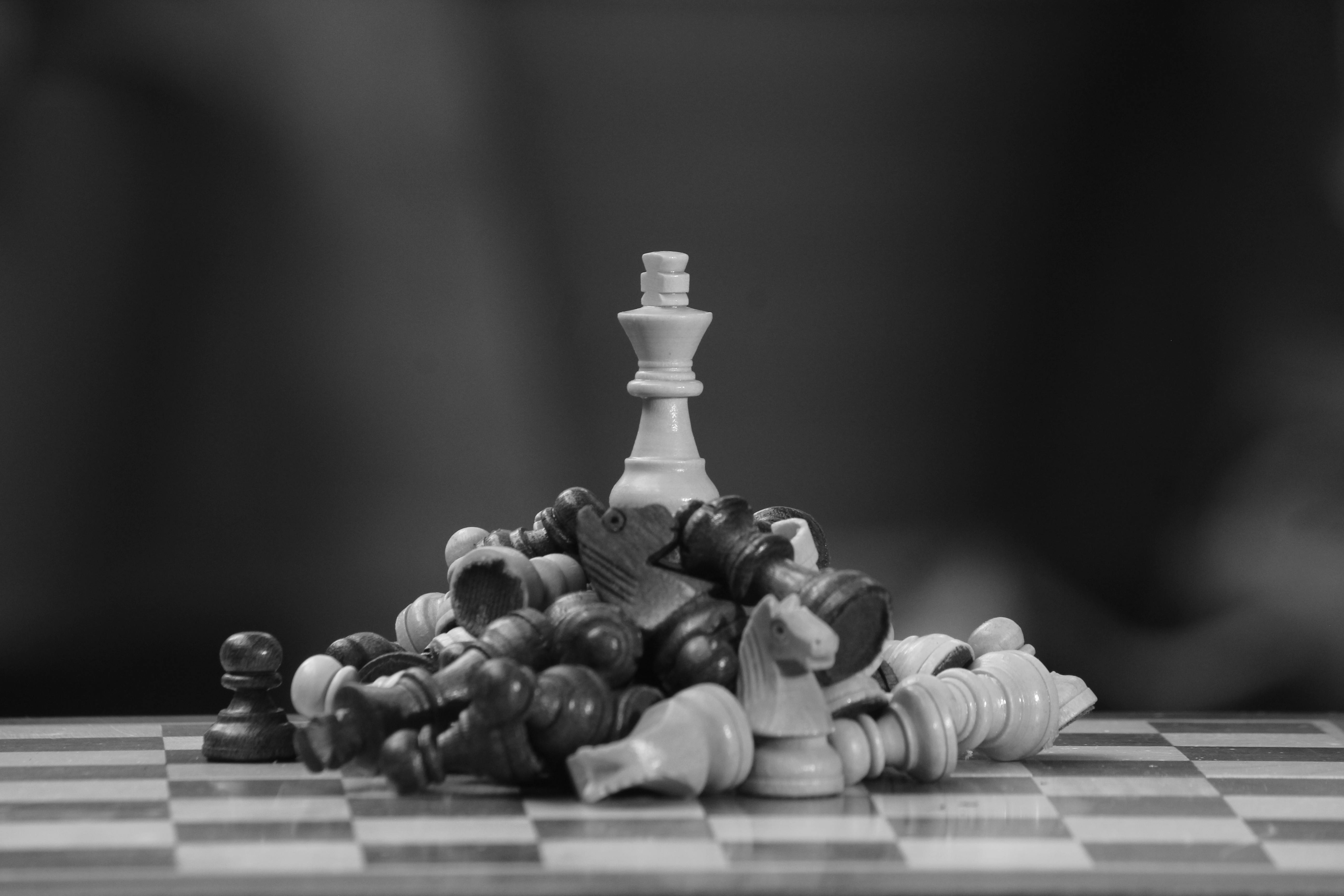 Victorious Chess King Surrounded by Fallen Pieces · Free Stock Photo
